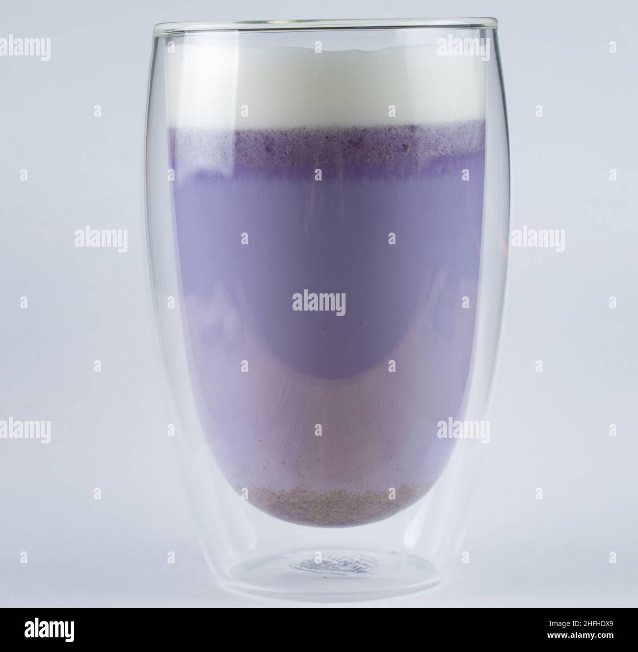 Purple goji matcha on blue background. Matcha cocktail in double glass ...