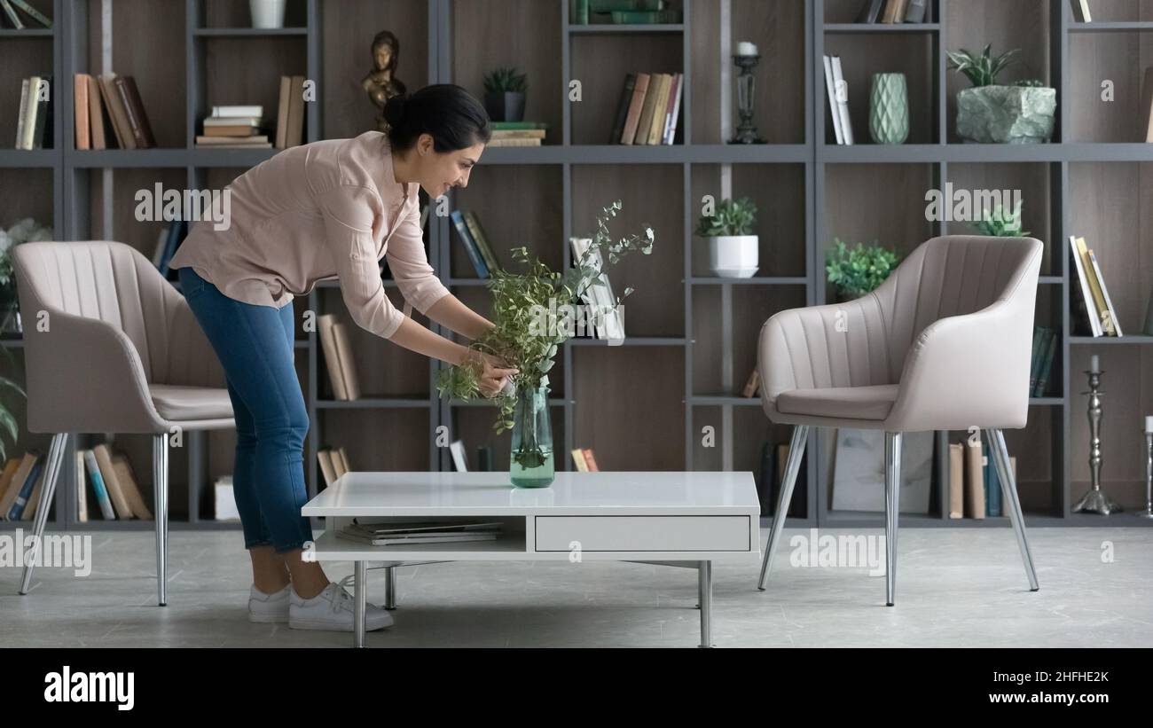 Happy tidy young Indian woman improving interior Stock Photo - Alamy