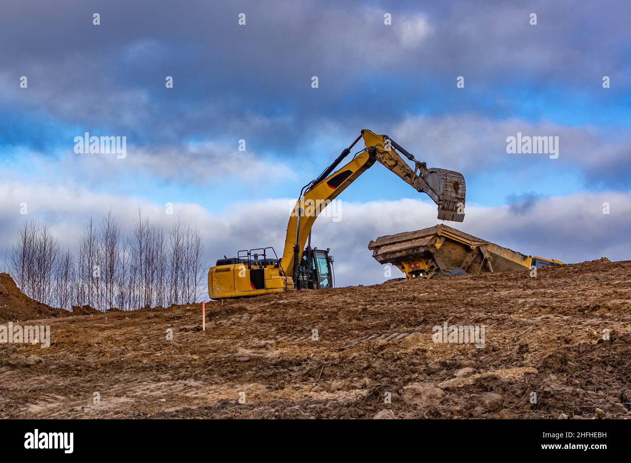 Excavator and Articulated Dump Truck on site Stock Photo - Alamy