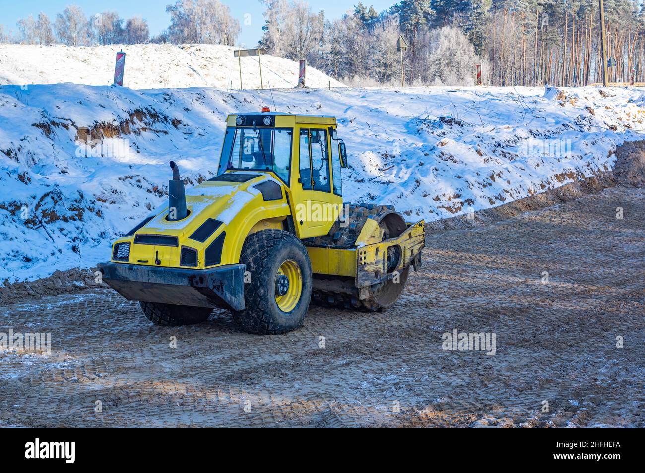 Yellow Padfoot roller compactors on-site in snow Stock Photo - Alamy
