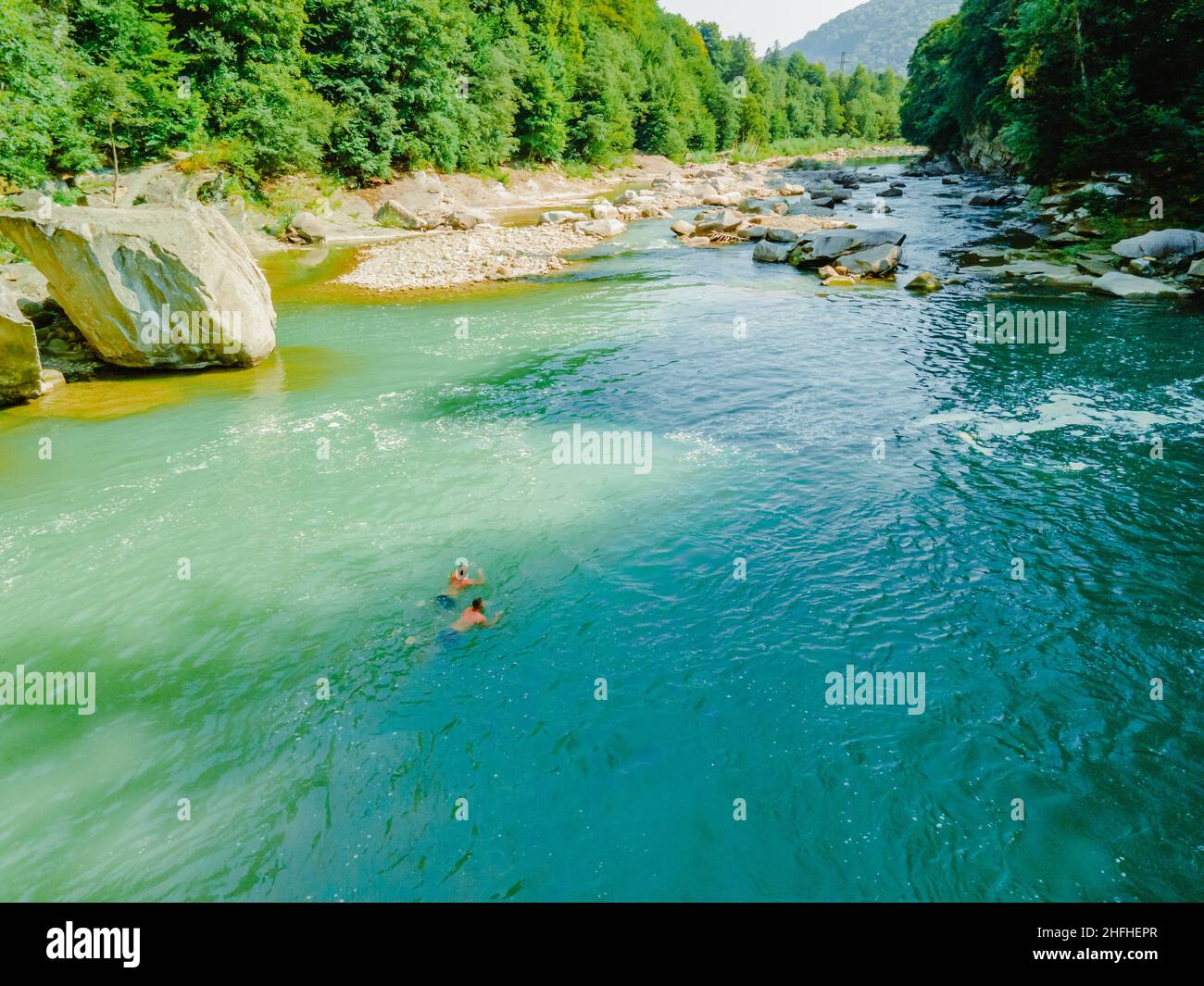 two men swimming in mountain river blue clear water Stock Photo - Alamy