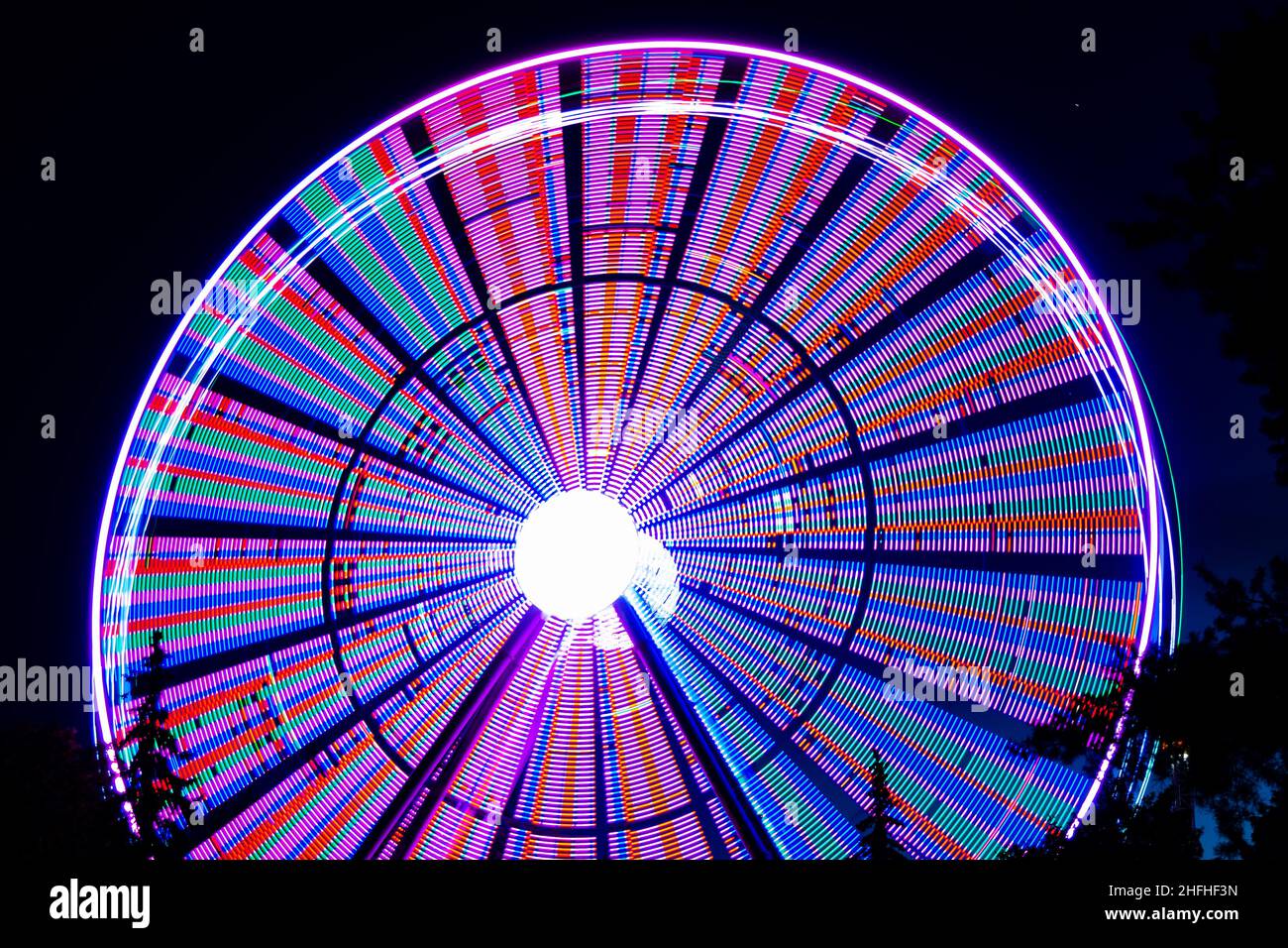 A blurry abstract Ferris wheel in an amusement park in the evening in ...
