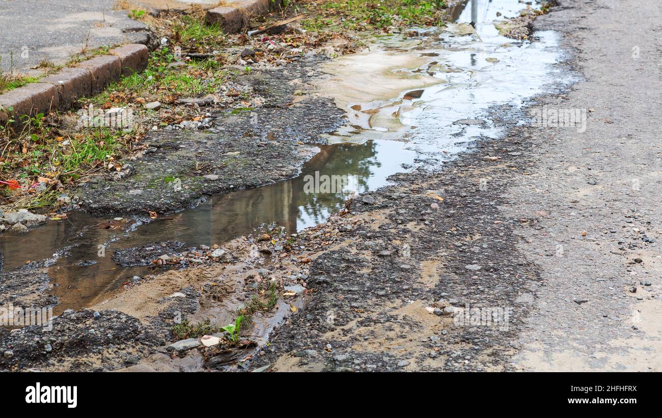 A road damaged by rain and snow, that is in need of maintenance. Broken ...