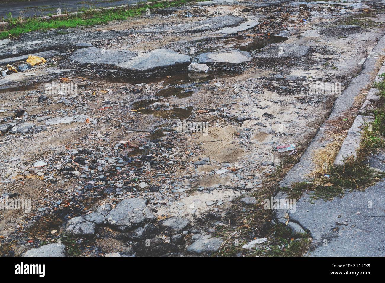 A road damaged by rain and snow, that is in need of maintenance. Broken ...