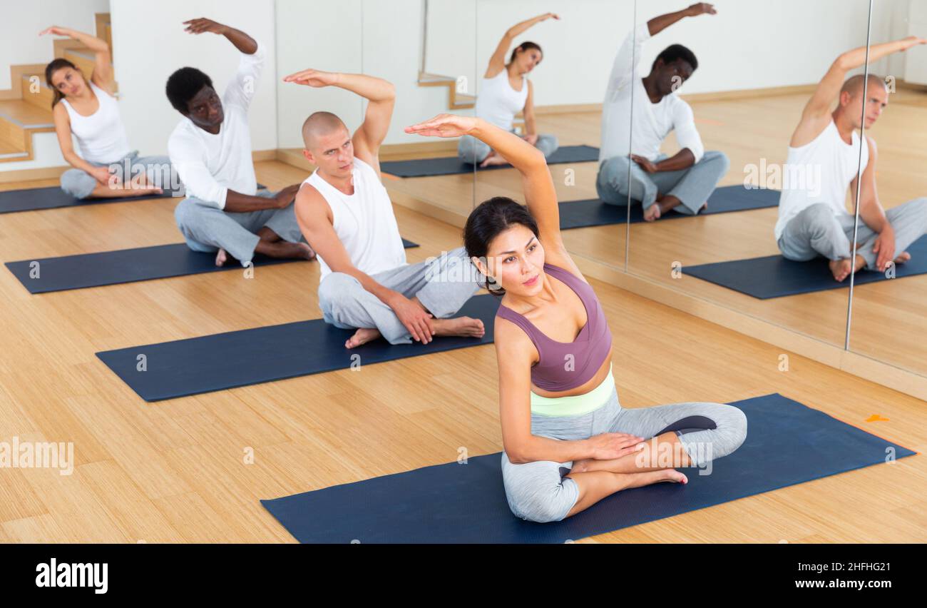 Group of sporty people practicing yoga positions during training Stock ...