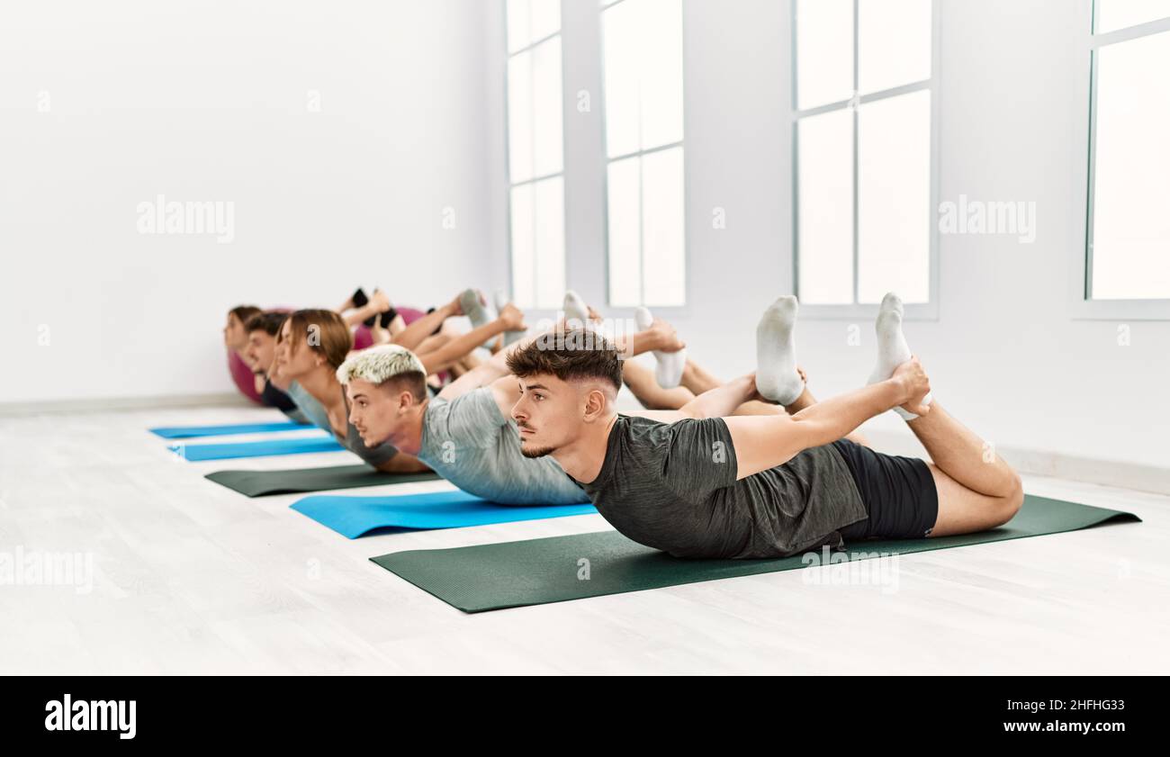 Group of young hispanic people with serious expression stretching at ...