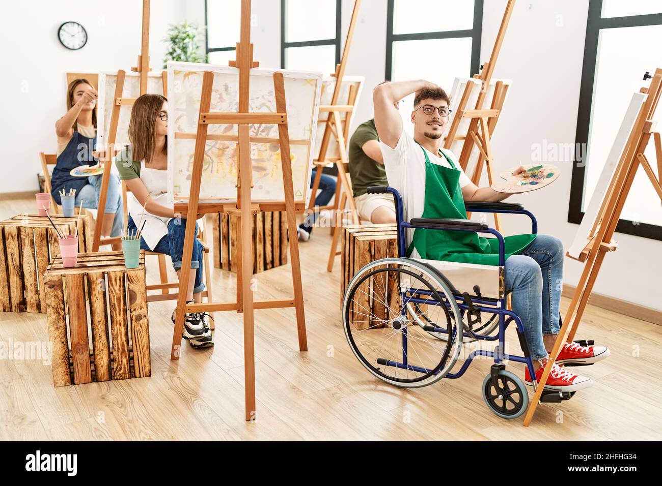 Young disabled man sitting on wheelchair drawing at art studio stressed ...