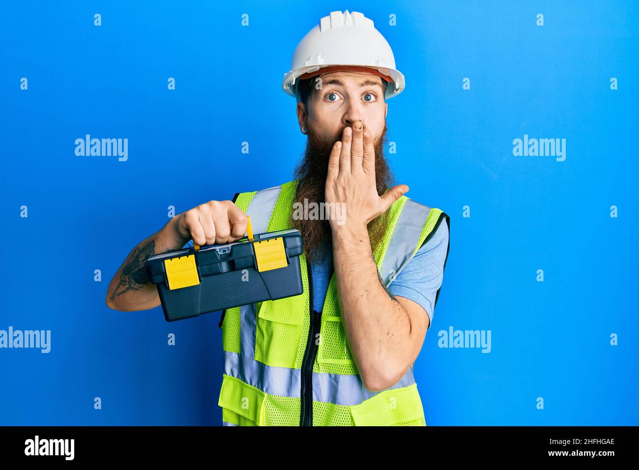 Redhead man with long beard wearing safety helmet and reflective jacket ...