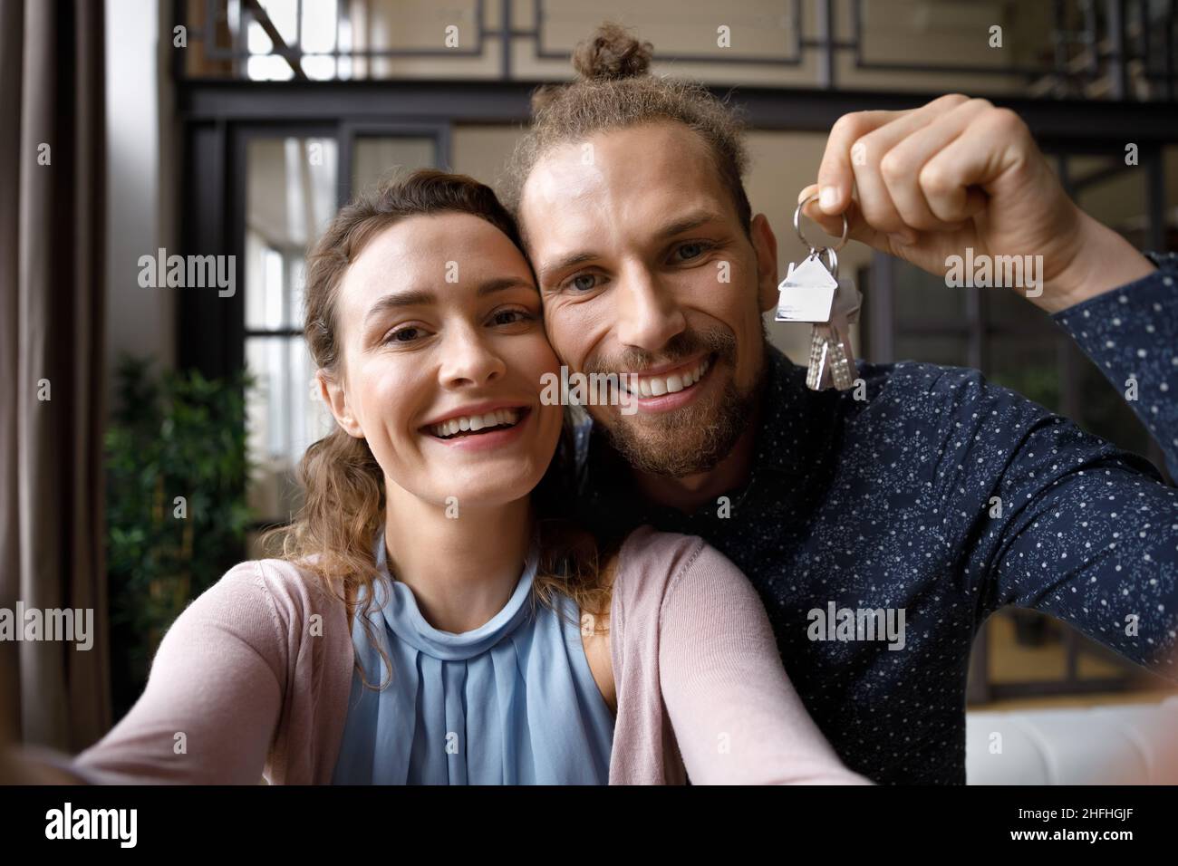 Happy loving young couple showing keys to camera Stock Photo - Alamy