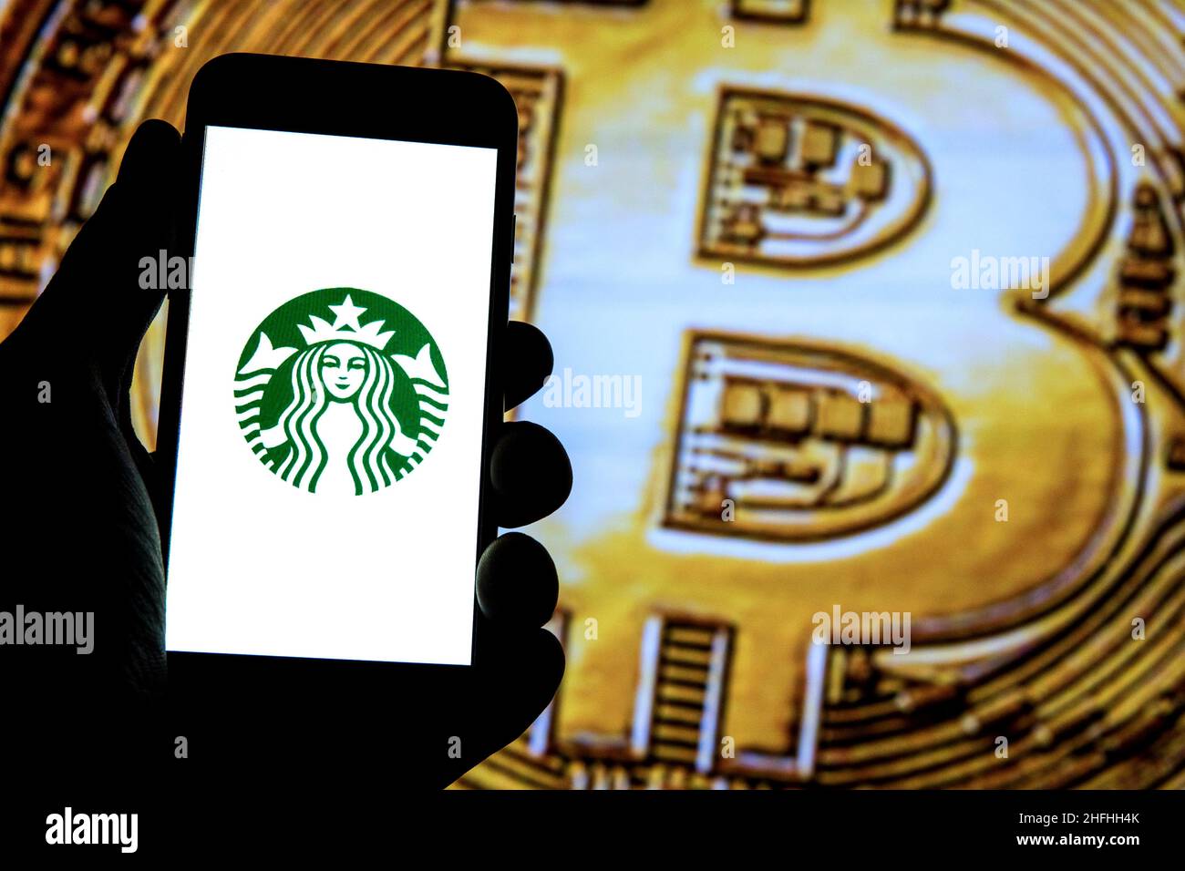 In this photo illustration a Starbucks logo seen displayed on a ...