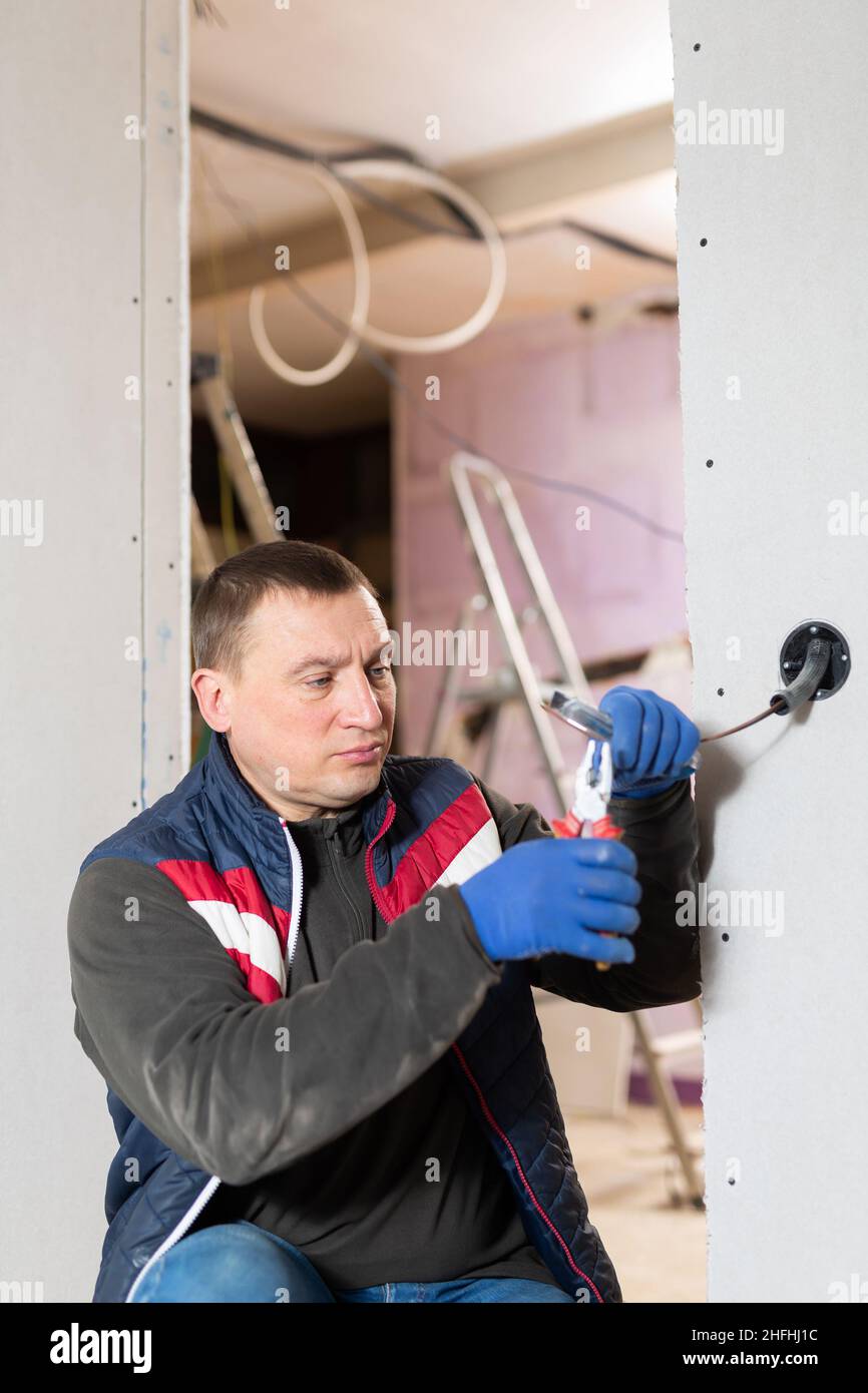 Electrician working with wires in apartment Stock Photo - Alamy