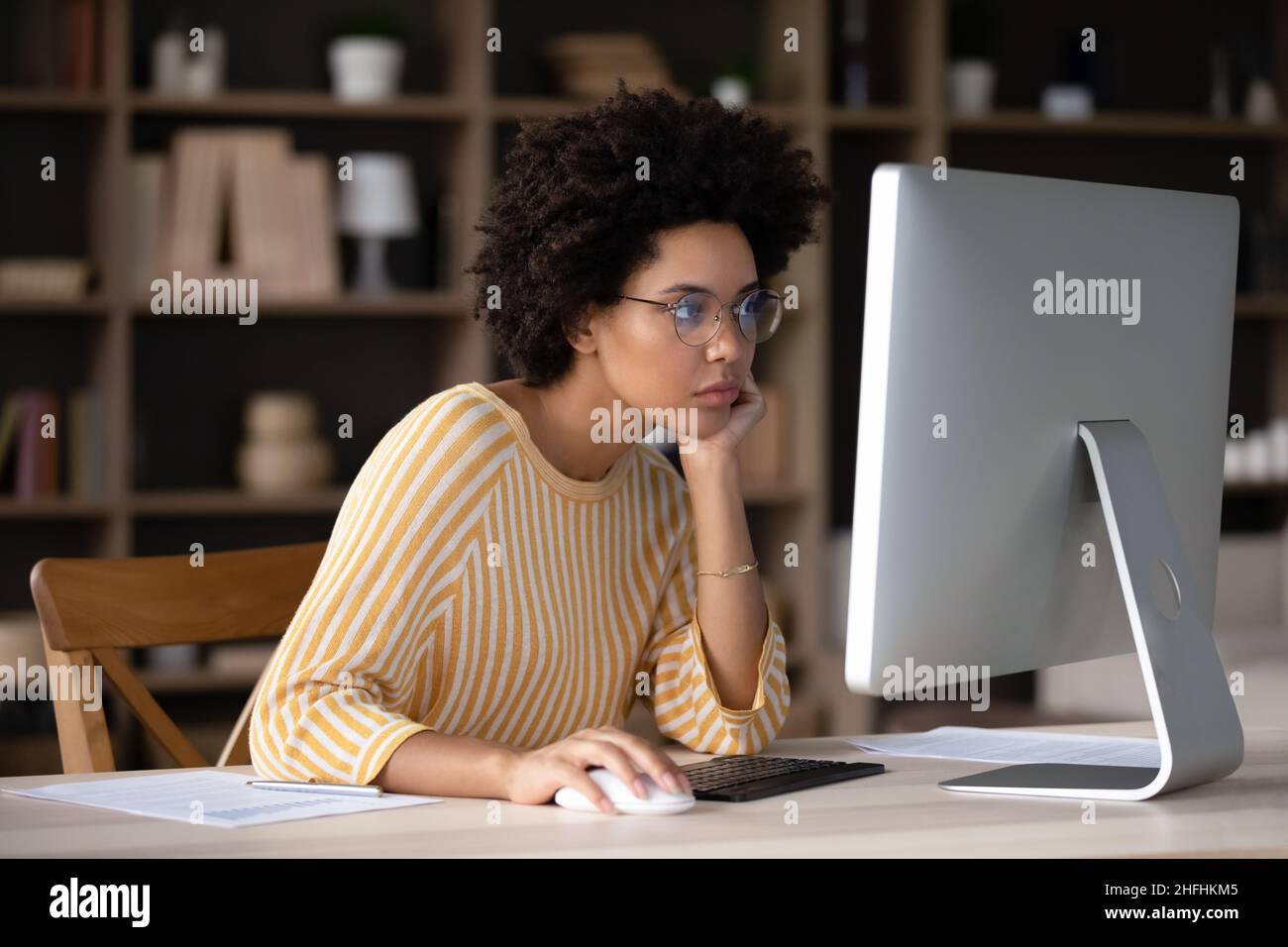 Thoughtful young African American business woman working on computer ...