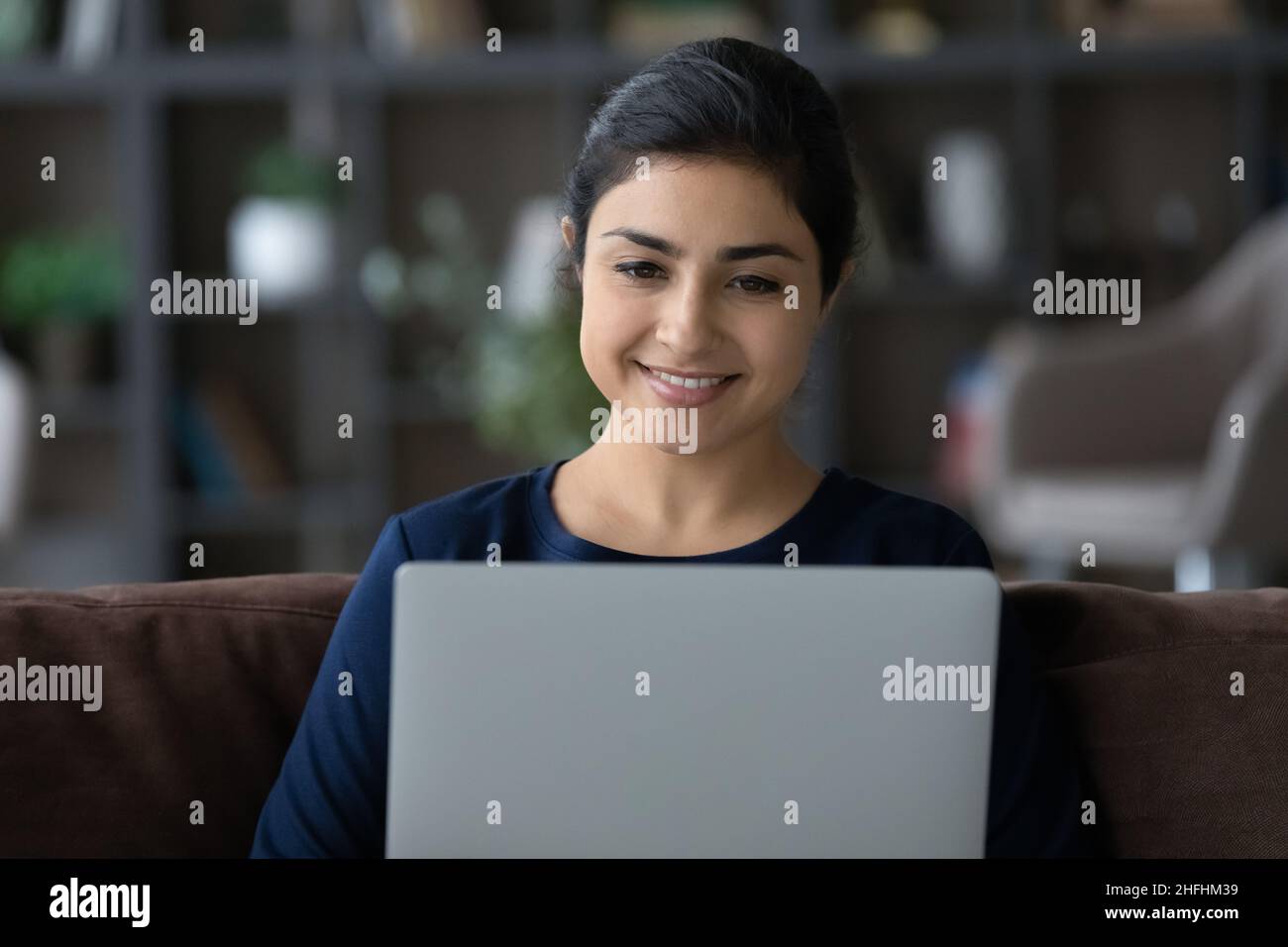 Happy attractive millennial Indian woman using computer Stock Photo - Alamy
