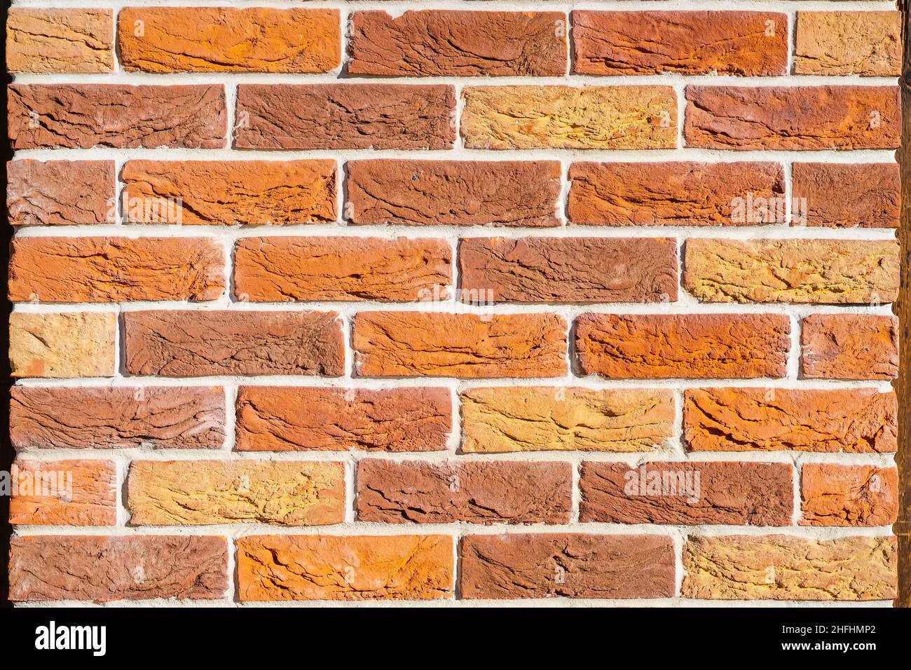 Texture of colorful red stone brick wall. For backgrounds and backdrops ...