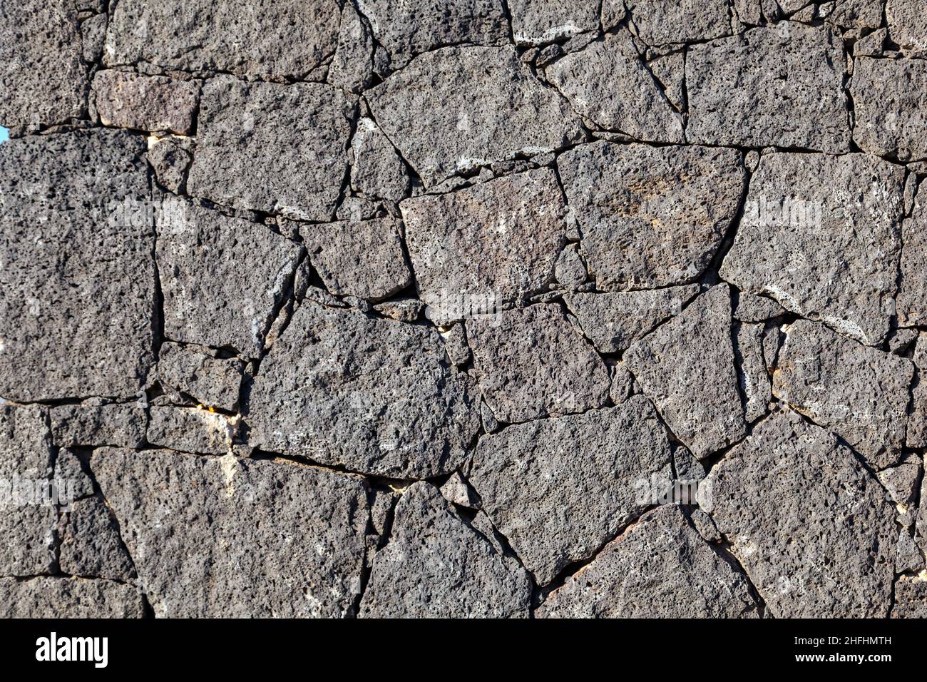 Texture of the black volcanic rock wall from Lanzarote, Canary Islands ...