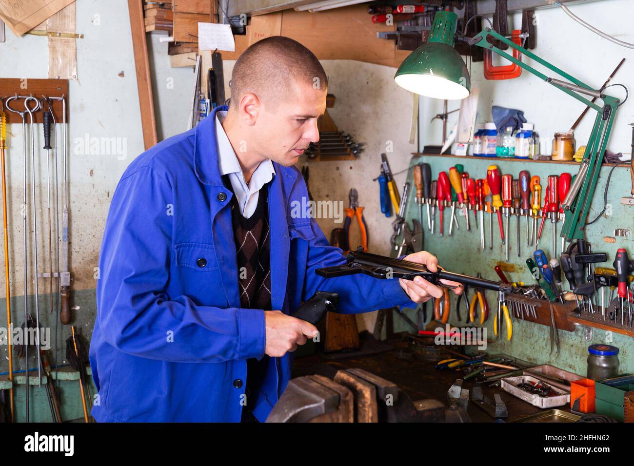 Gun repairman disassembling sporting handgun before preventive ...