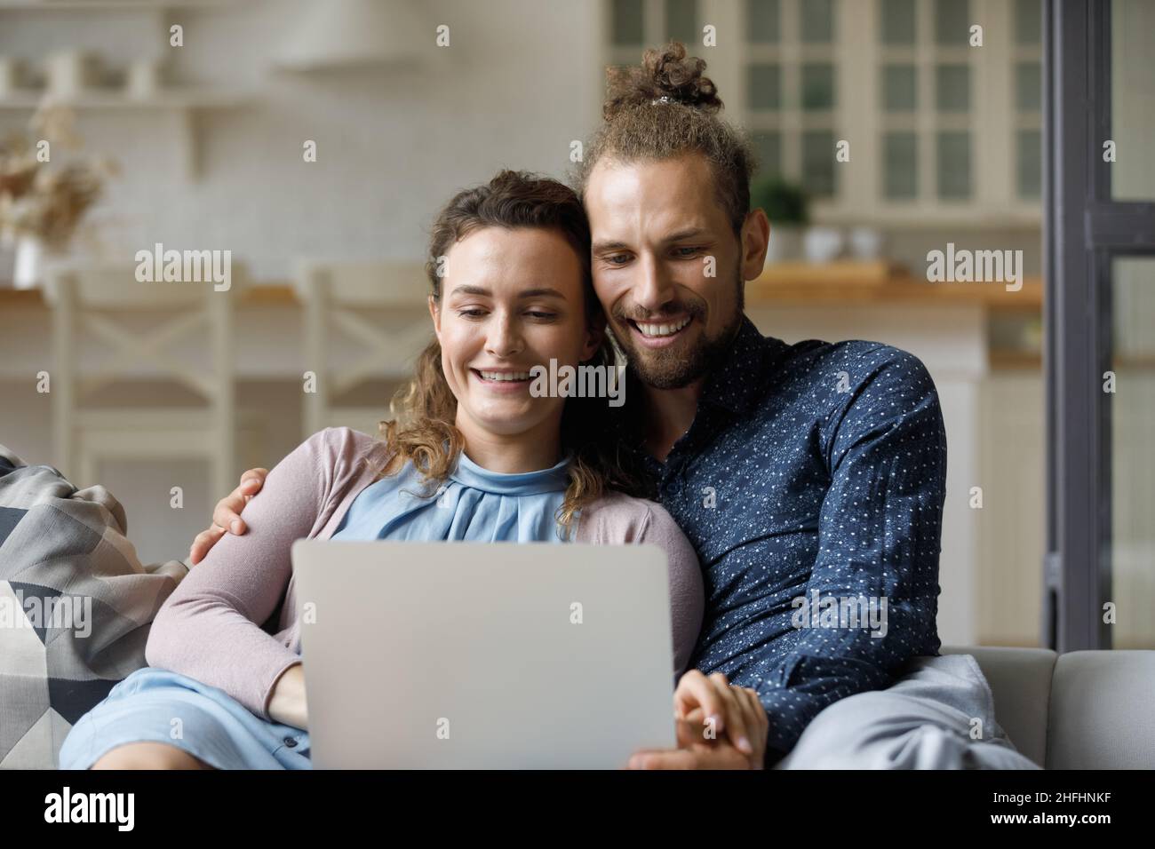 Smiling millennial family couple using computer at home Stock Photo - Alamy