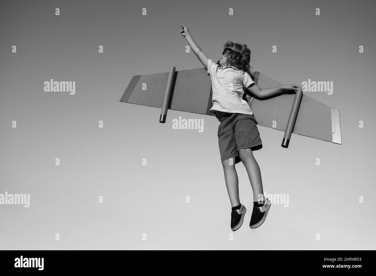 Kids leader and winner, success start up. Boy pilot fly against a blue ...