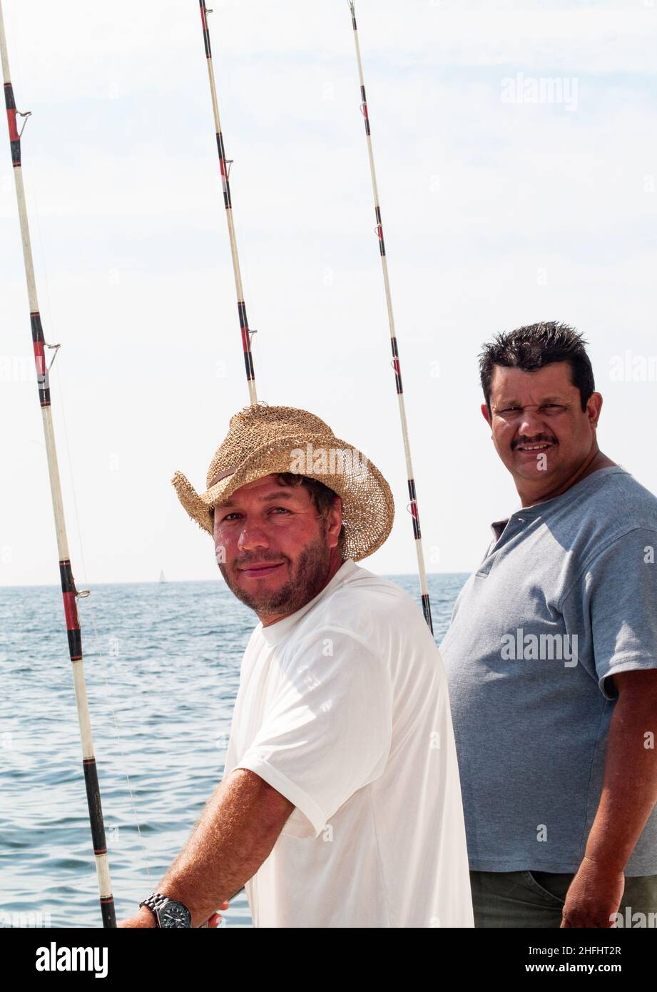 Reeling in Charter fishing boat Stock Photo - Alamy
