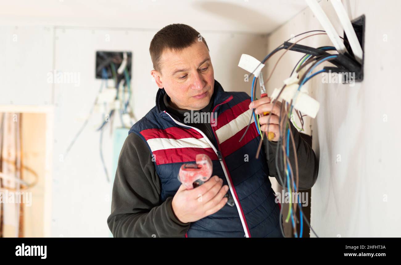 Electrician working with wires in apartment Stock Photo - Alamy
