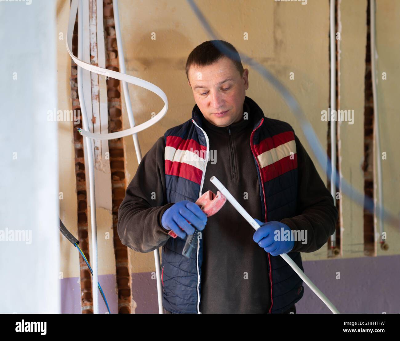 Repair man cutting cable duct for wires Stock Photo - Alamy