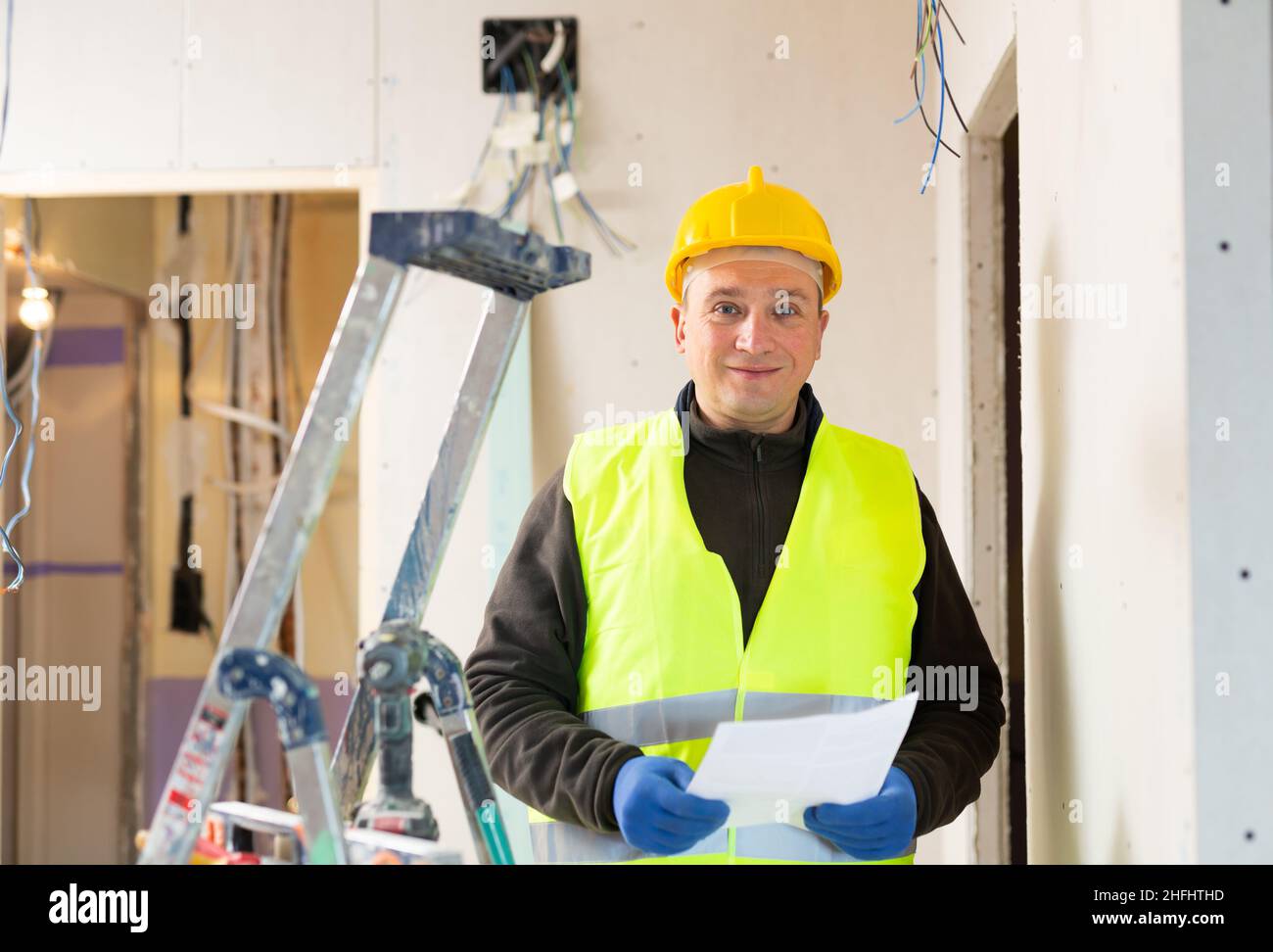 Repair man standing in apartment with documentation Stock Photo - Alamy