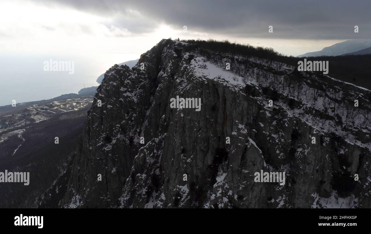 The slope of the high rock massif covered with pine trees in misty ...