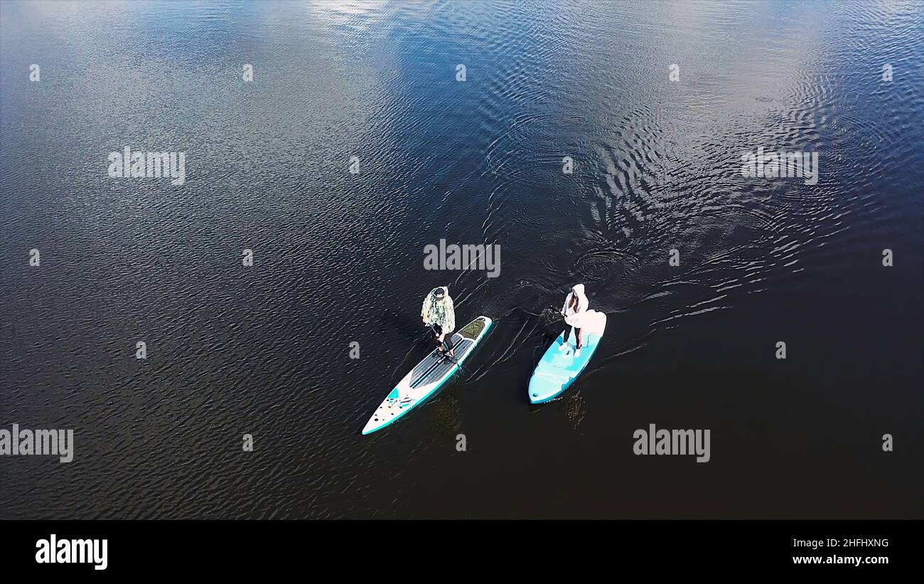 Top view of a couple doing paddle boarding on lake, sport and lifestyle ...