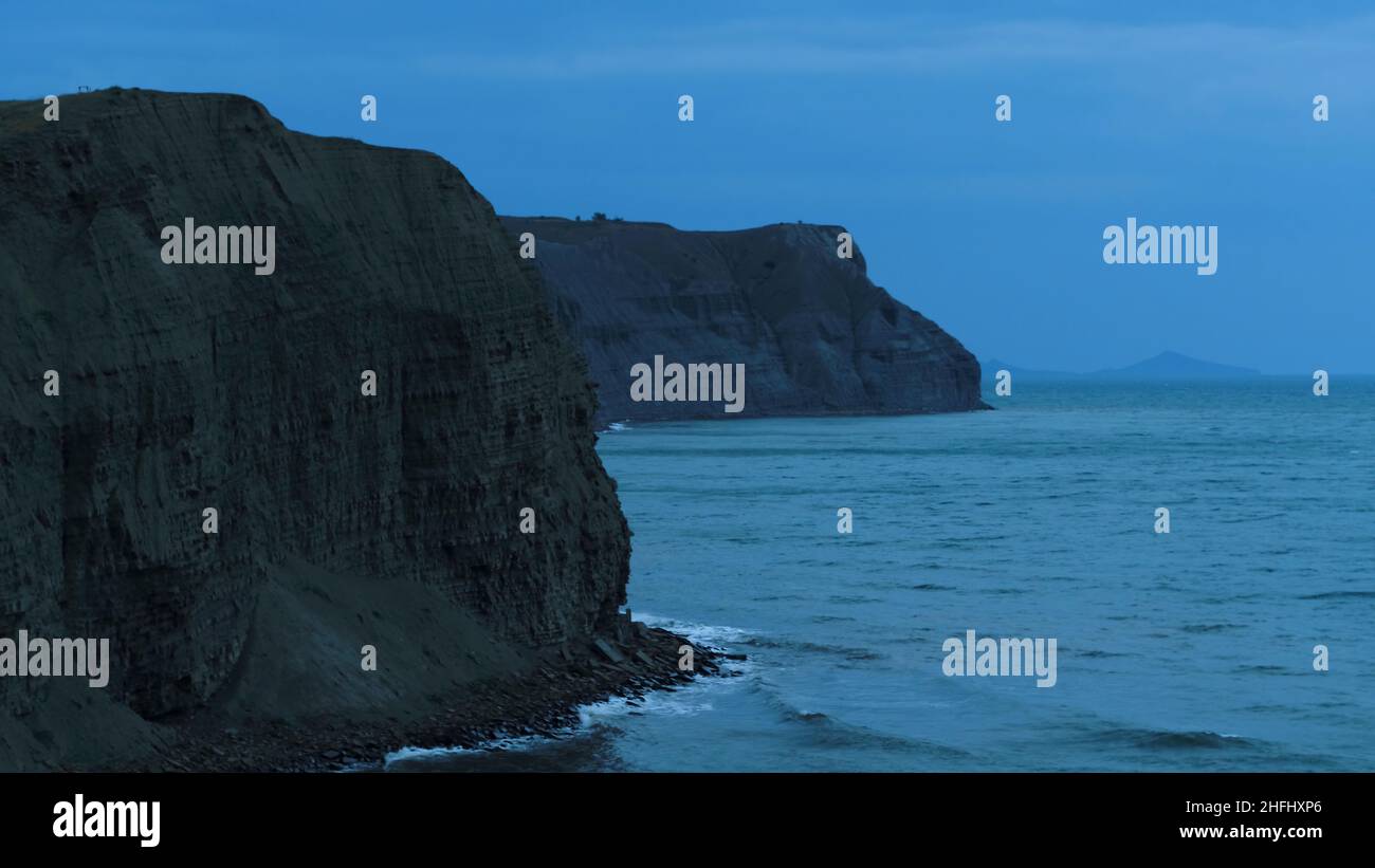 Stunning seascape with a steep cliff on dark blue sky background ...