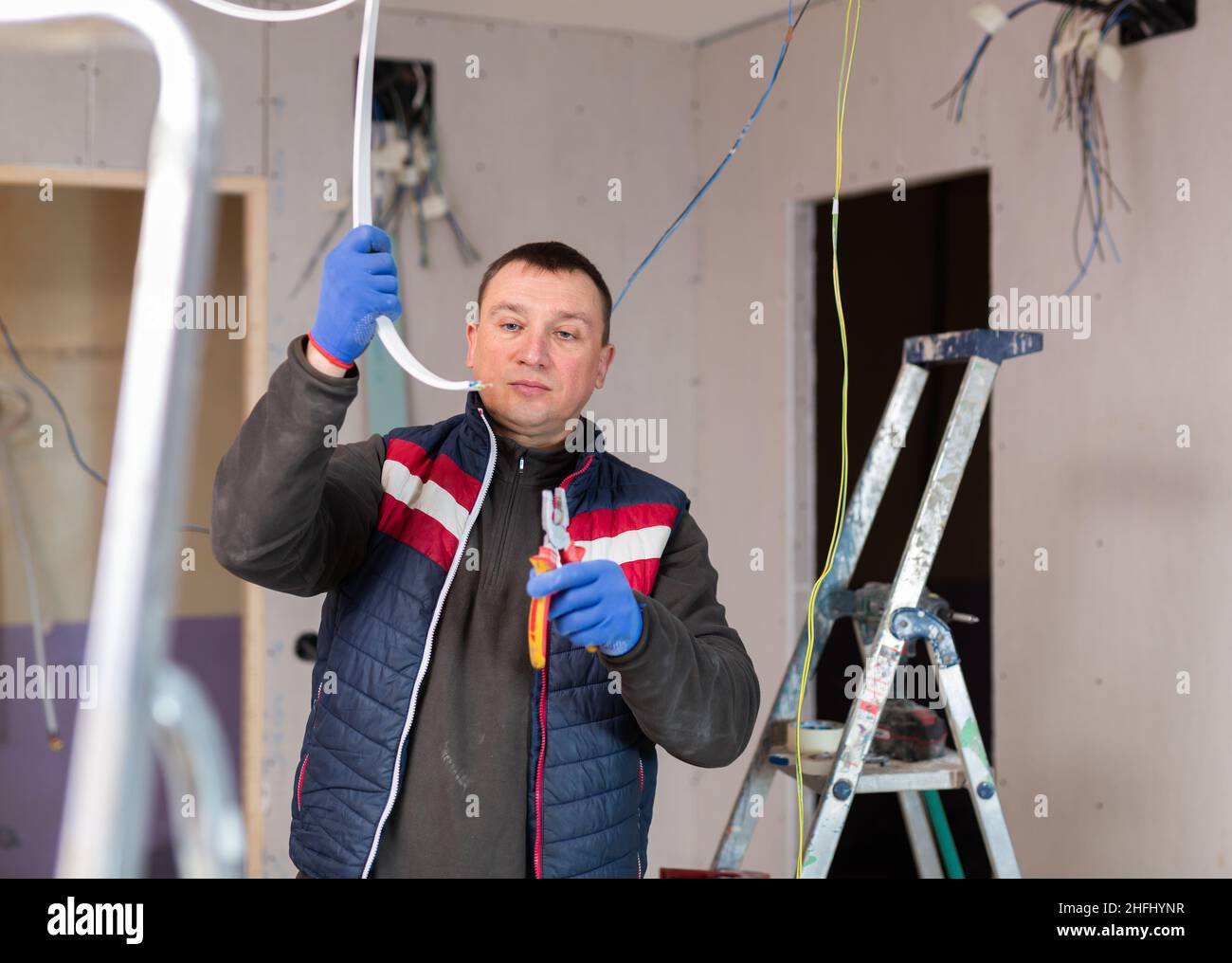 Electrician working with wires in apartment Stock Photo - Alamy