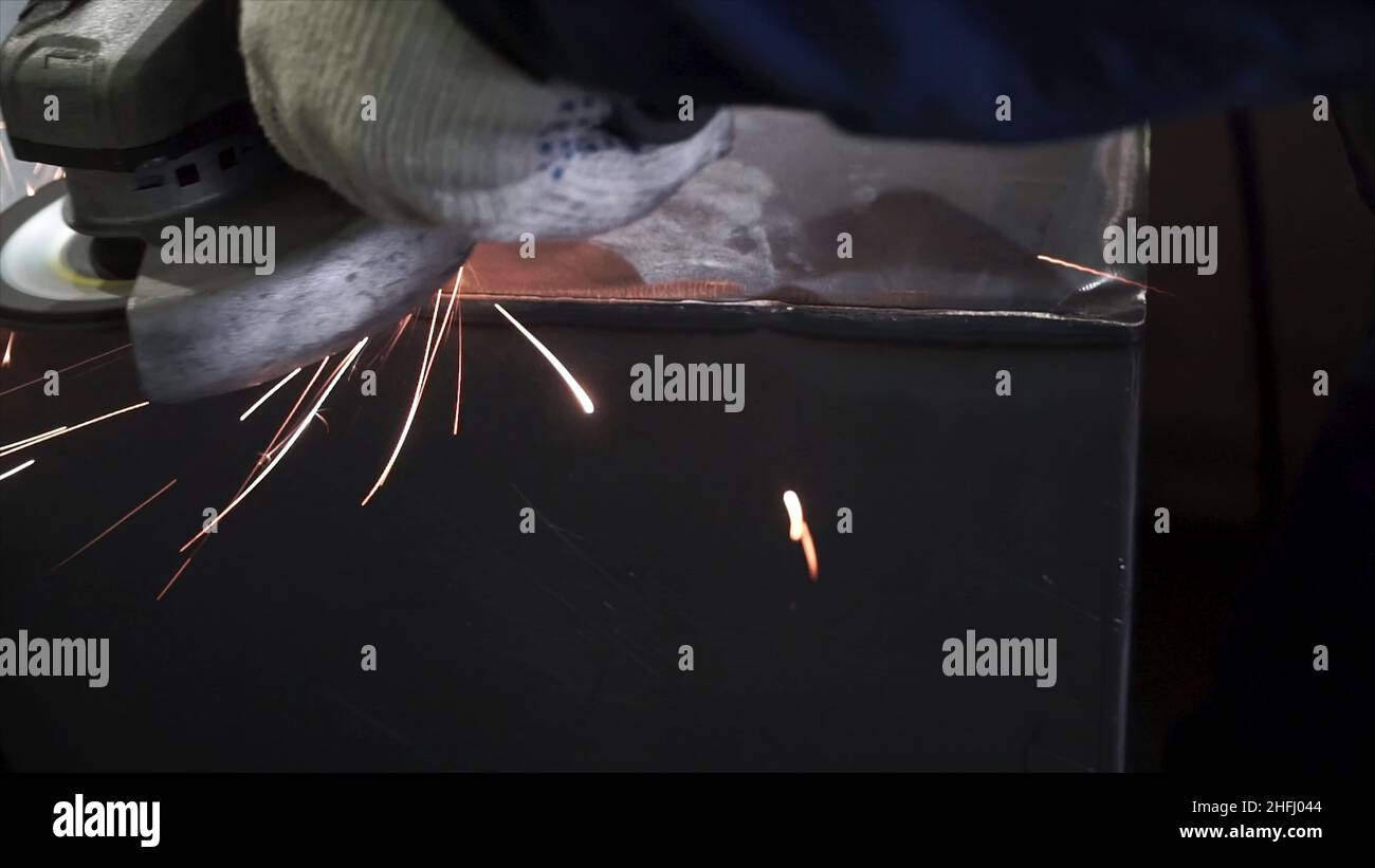 Metal polishing with a hand sander with a polishing disk. Clip. Factory ...