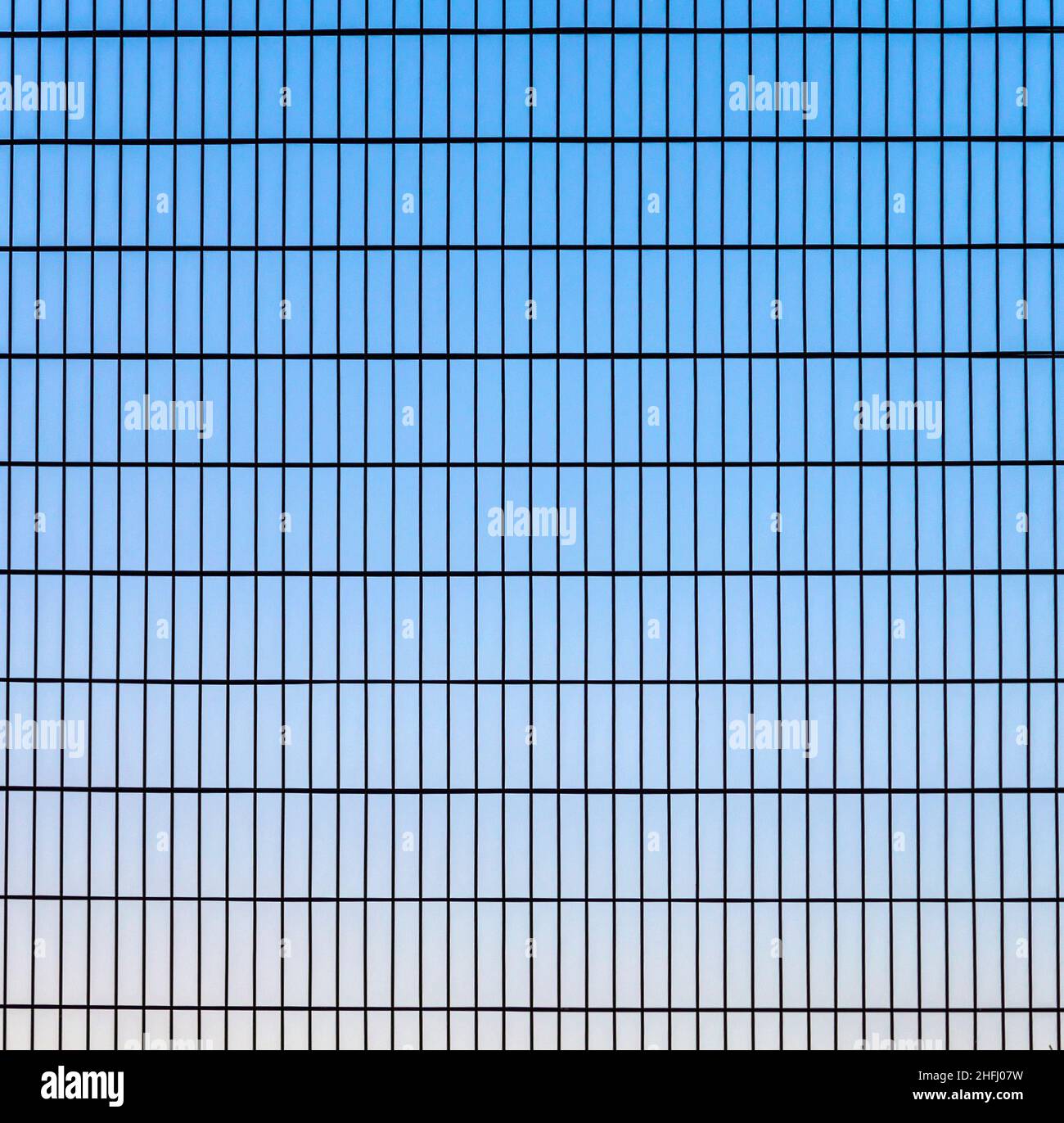 fence with grid structure with blue sky in background Stock Photo - Alamy