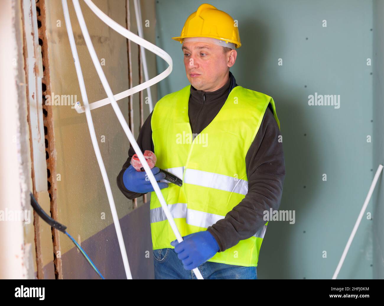 Repair man cutting cable duct for wires Stock Photo - Alamy
