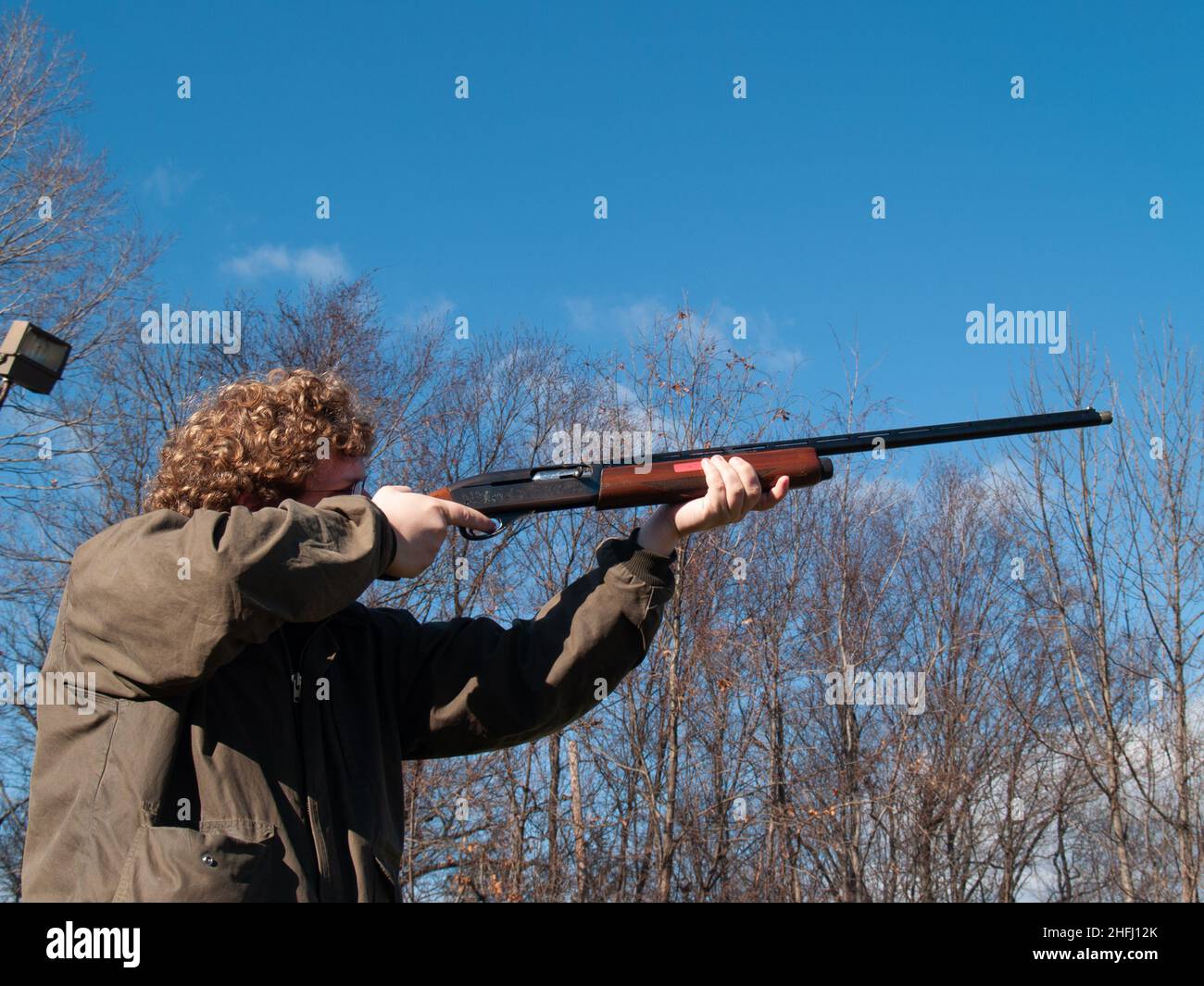 Young man skeet shooting Stock Photo - Alamy