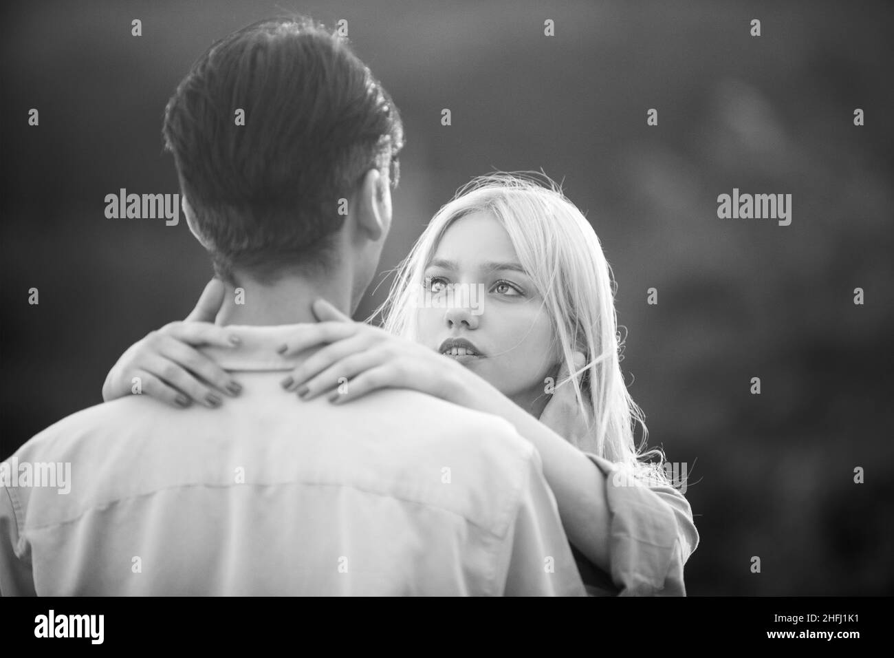 Couple lovers hugging and kissing at sunset. Young couple in love spends time together. Man ...