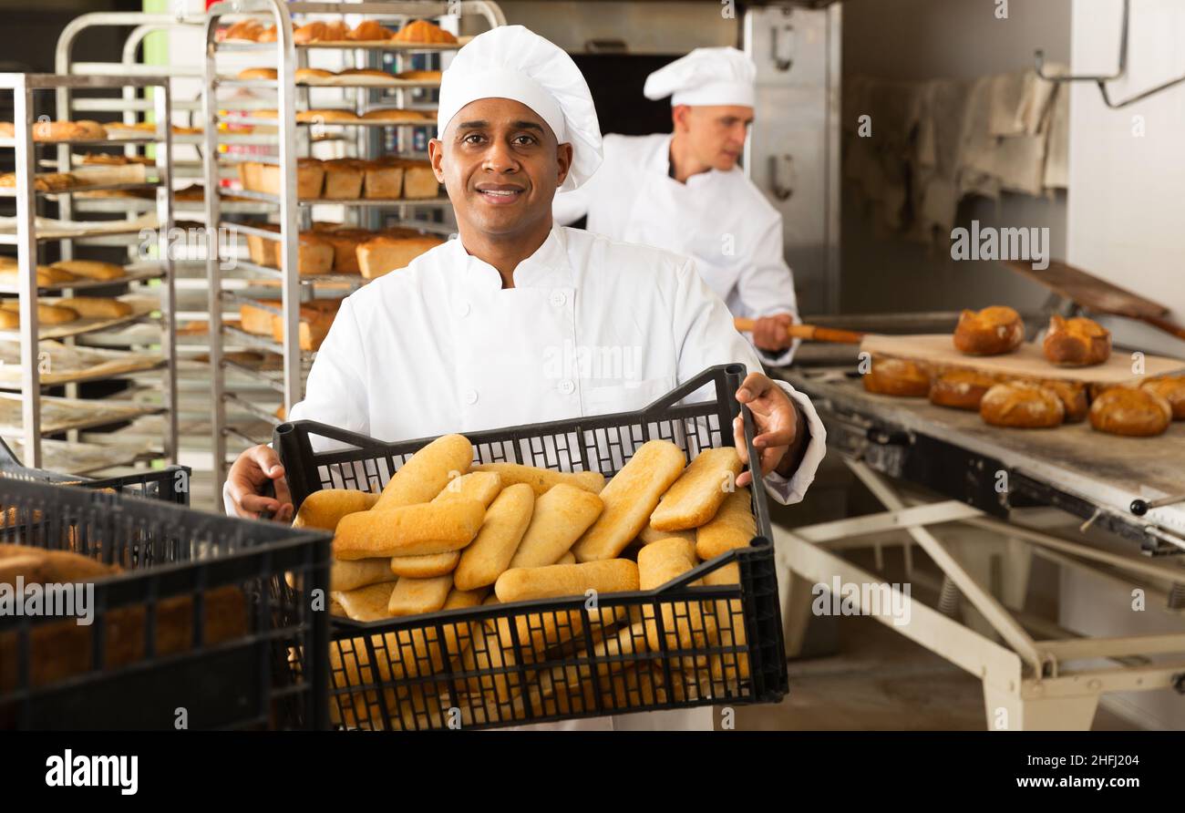 positive male baker with sesame bread in black box in kitchen Stock ...