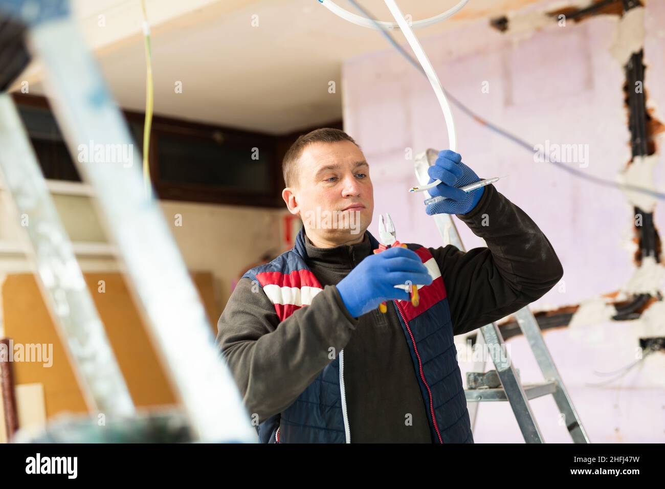 Electrician working with wires in apartment Stock Photo - Alamy