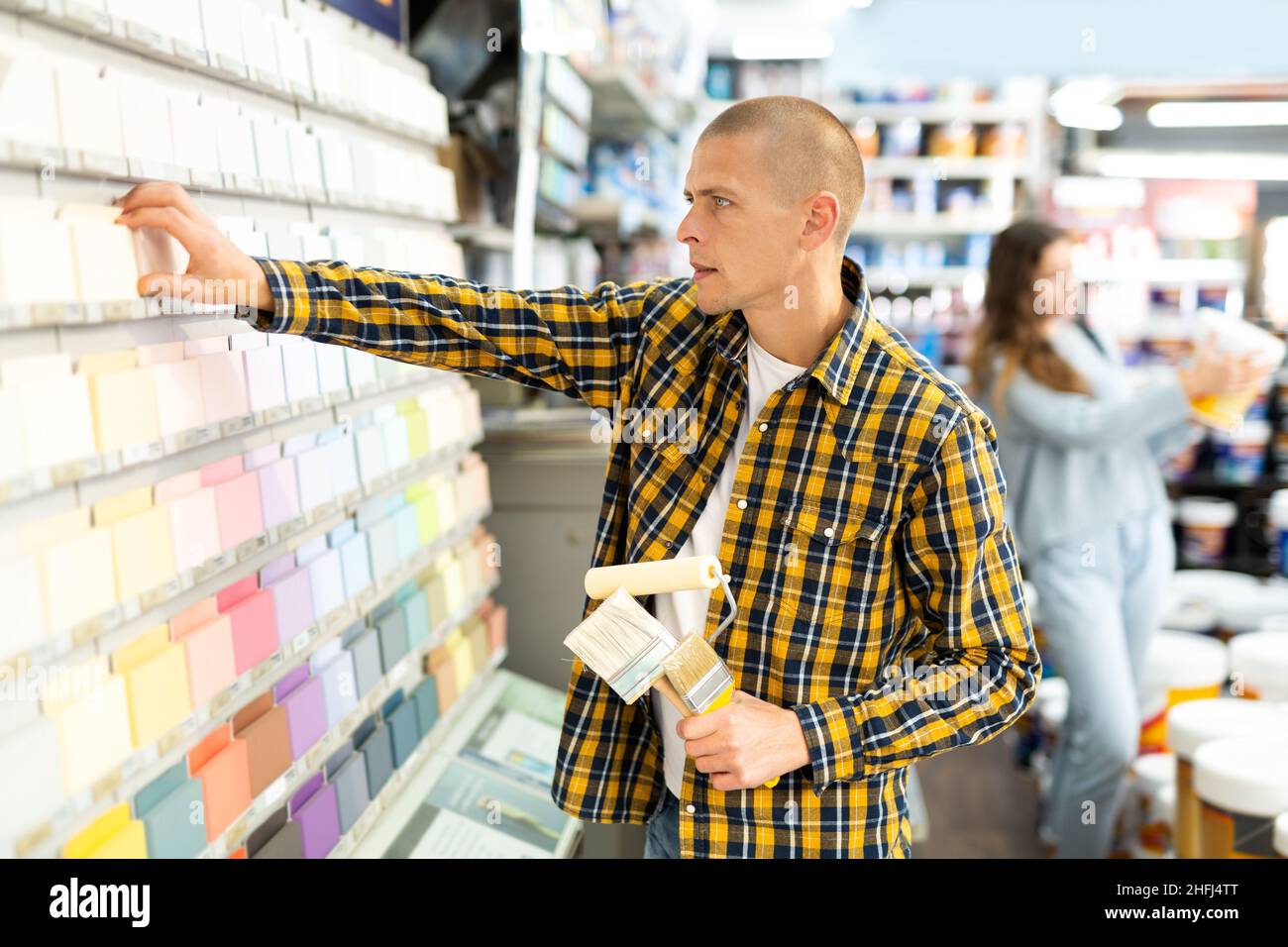 Young male customer choosing paint color for renovation works Stock ...