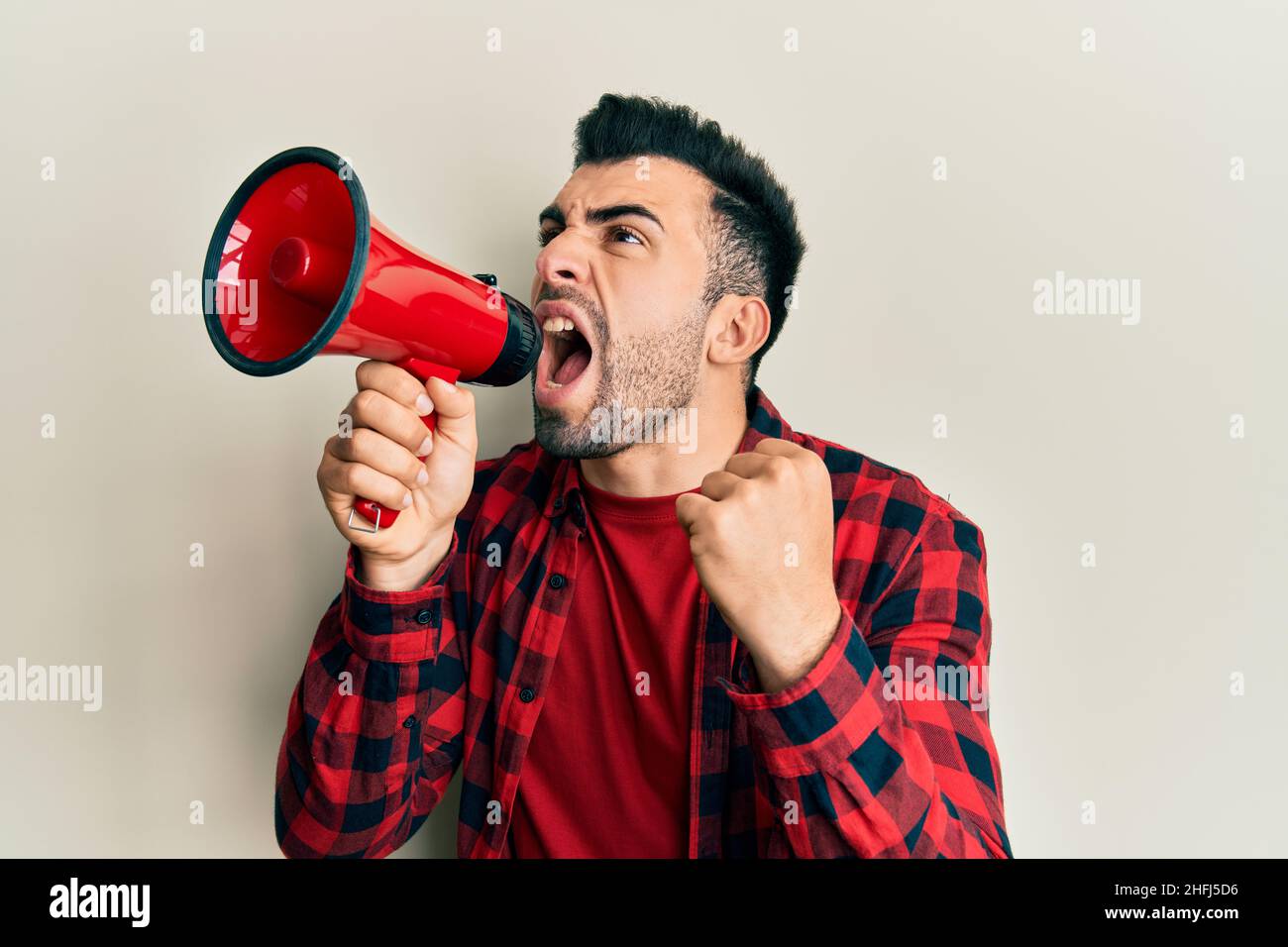 Hispanic man with beard screaming with megaphone Stock Photo - Alamy