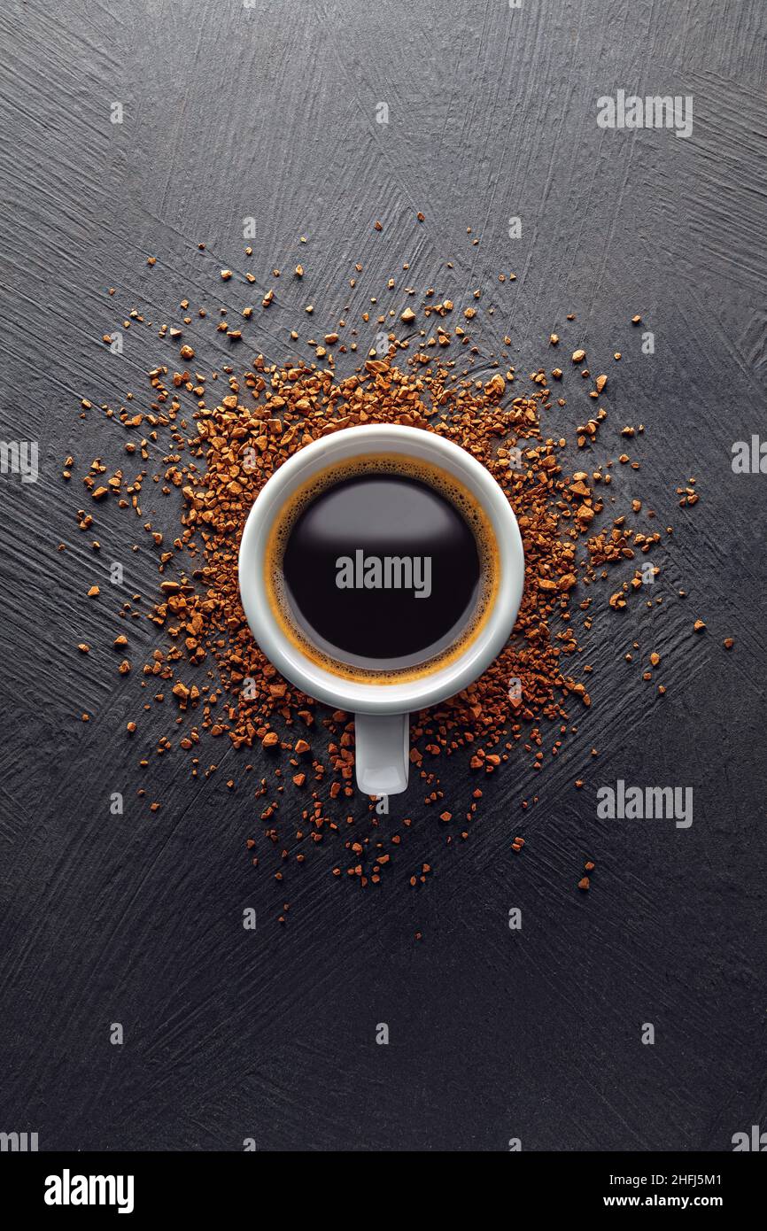 Coffee cup and instant powder on black background Stock Photo - Alamy