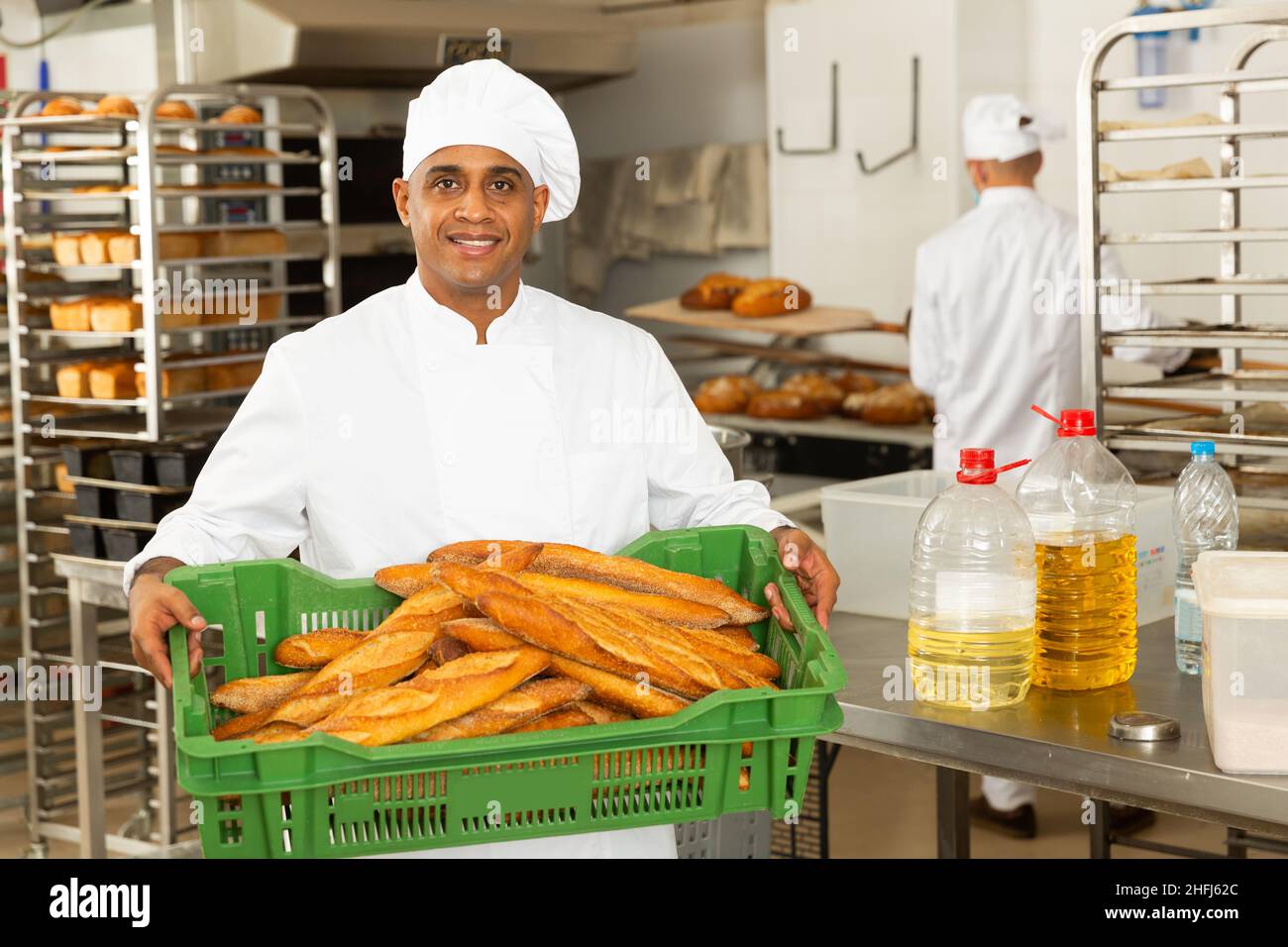 Baker with box with baguettes in bakery Stock Photo - Alamy