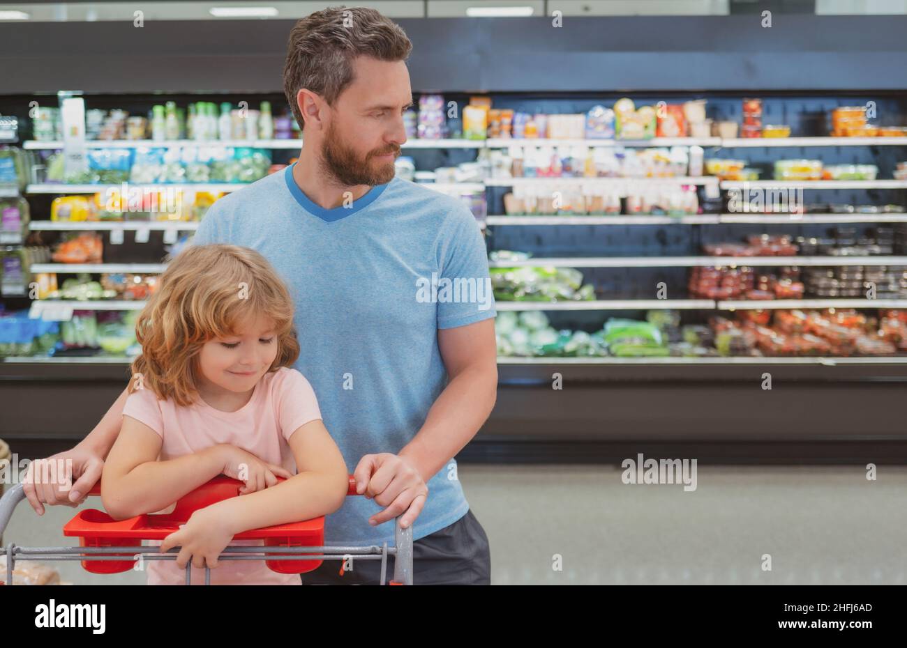 Father and son looking at product at grocery store. Dad with child in ...