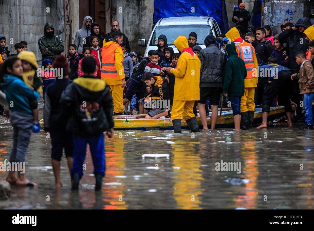 Palestinian firefighters evacuate residents from an inundated houses ...