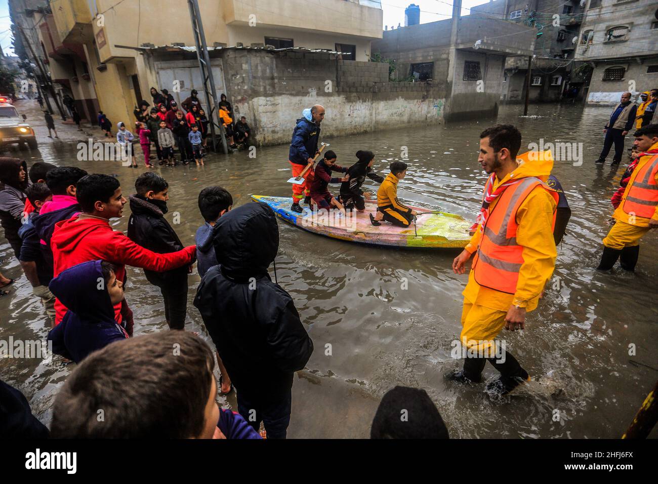 Palestinian firefighters evacuate residents from an inundated houses ...