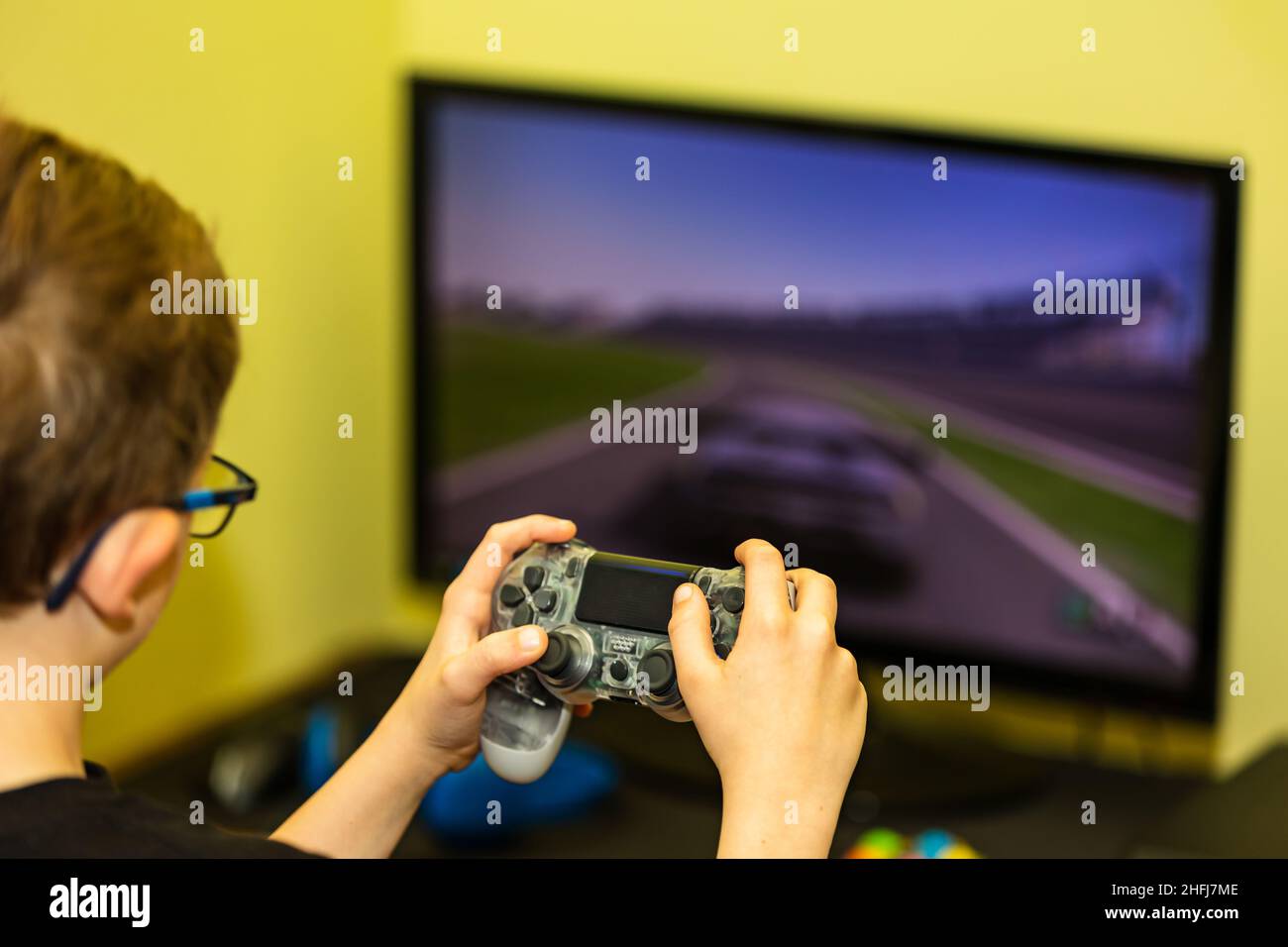 Kid using controller to play video game Stock Photo - Alamy