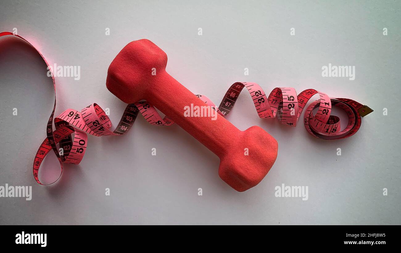 Top view of dumbbell and weight scale measure tap with white background ...