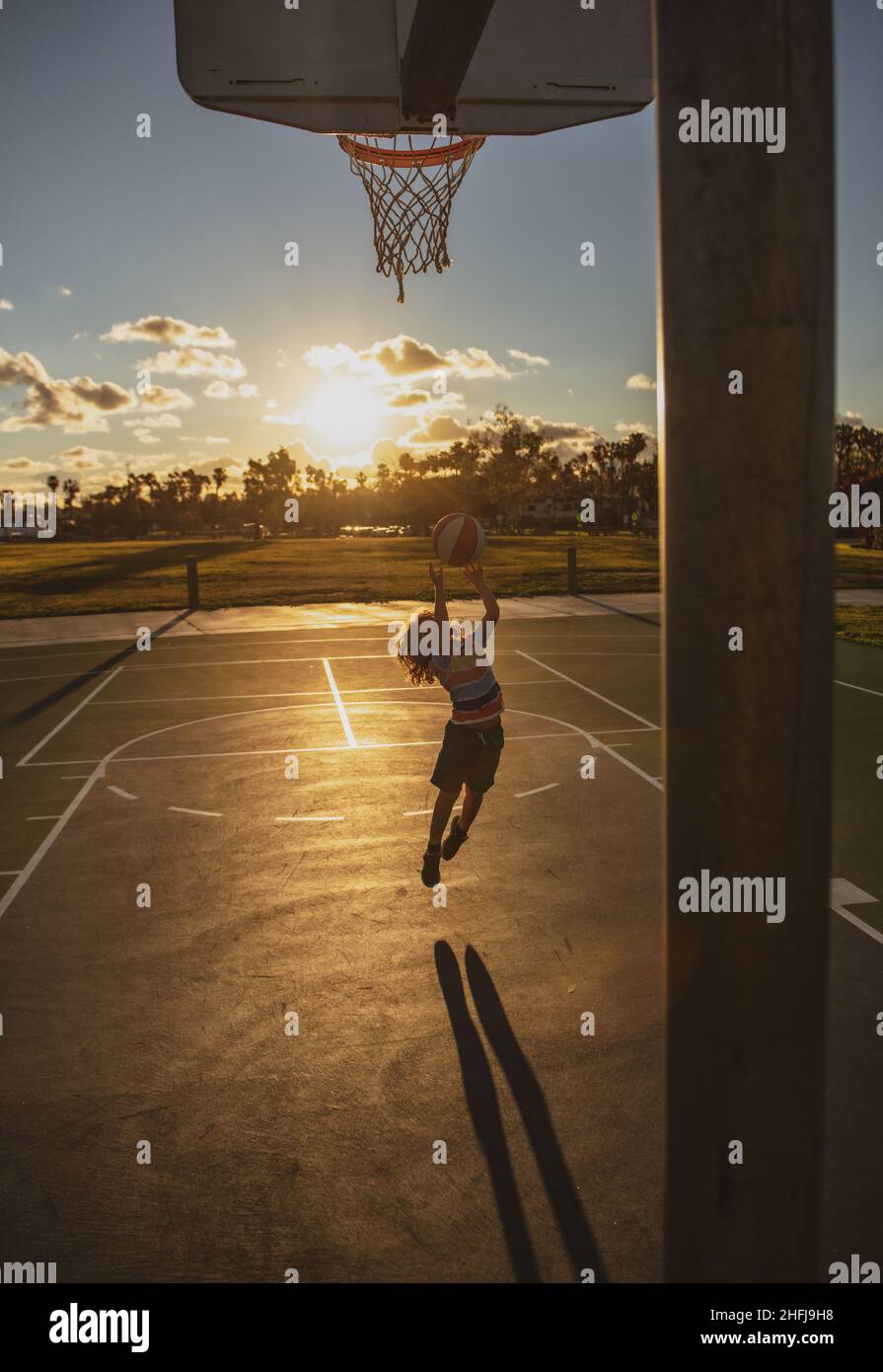 Cute child kid playing basketball on sunset Stock Photo - Alamy