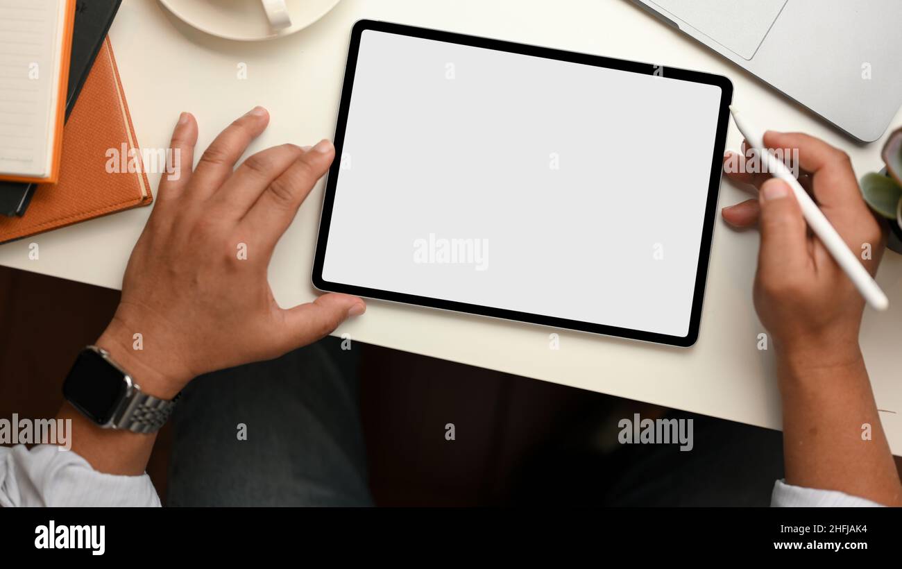 Successful businessman using portable tablet computer at his workspace ...