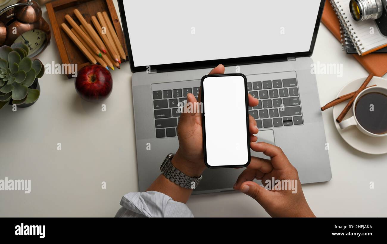 Mockup of a smartphone blank screen display in male's hands over modern ...