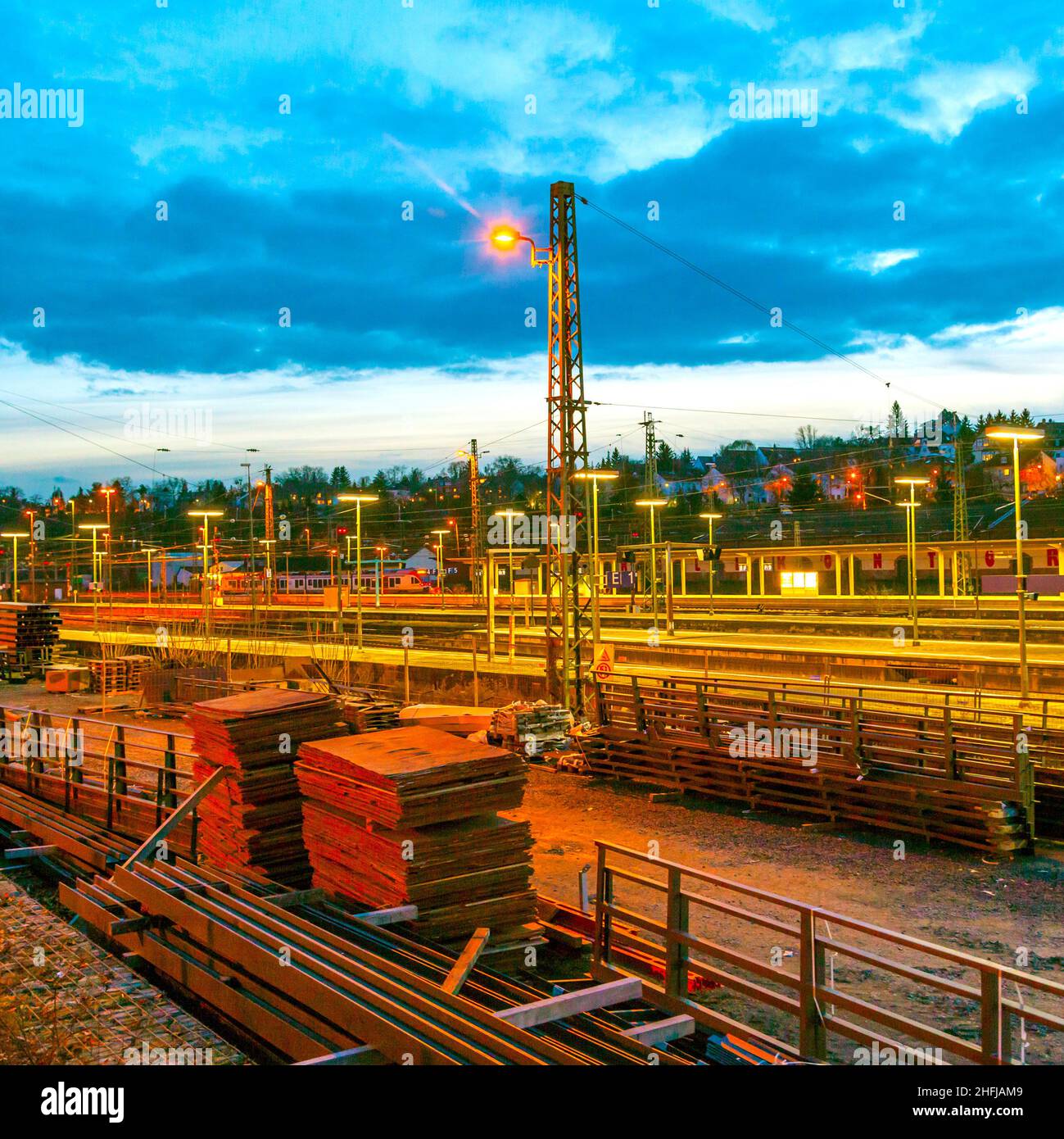 evening train traffic with rails and illuminated platform in the dark ...